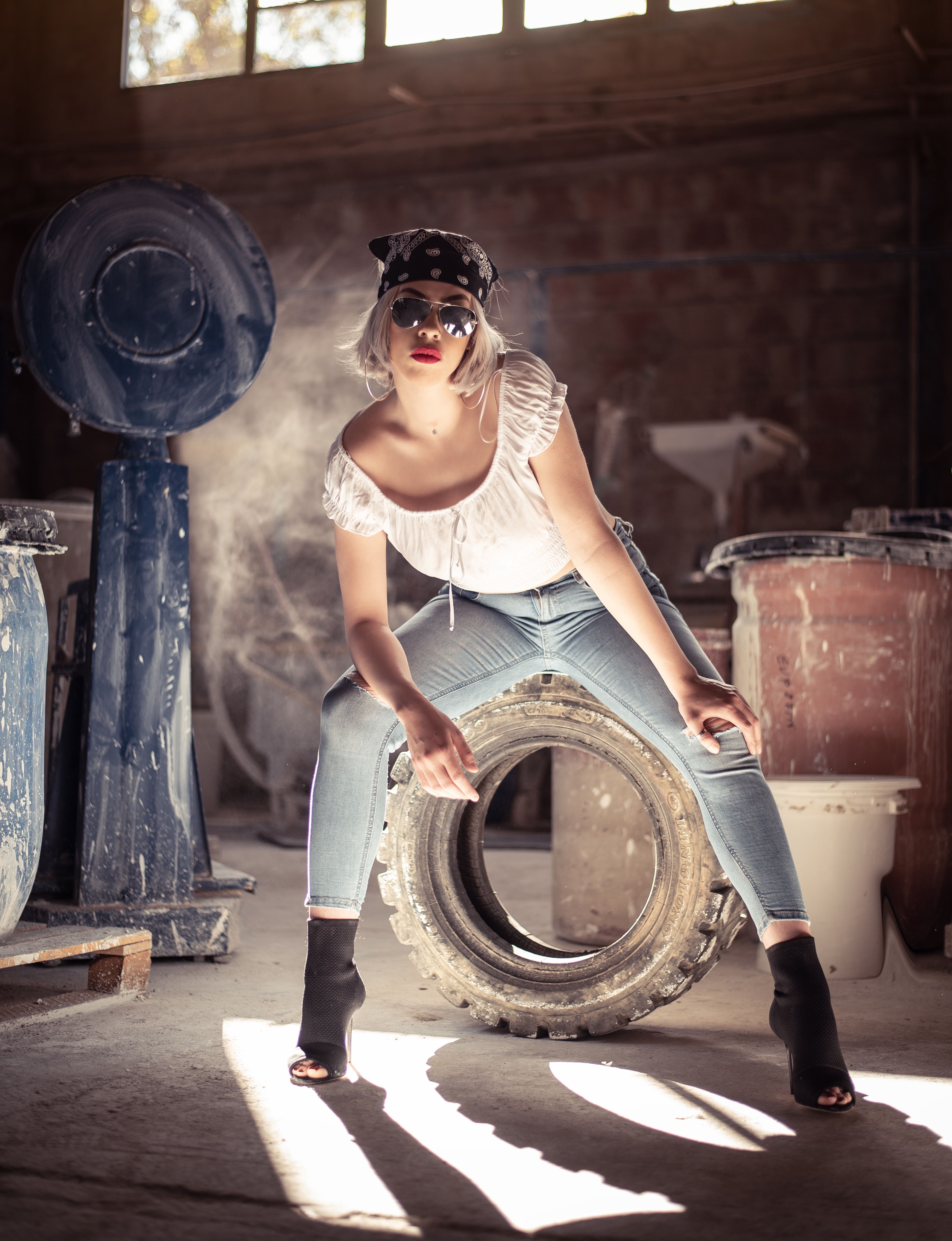 Woman Sitting on Tire in Garage · Free Stock Photo