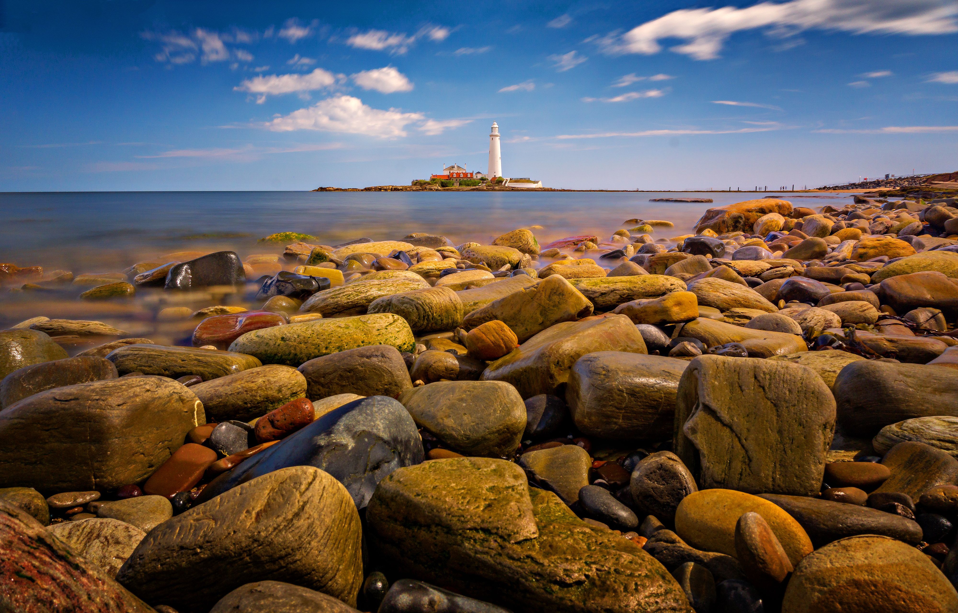 Stones on Shore against St. Mary Lighthouse · Free Stock Photo