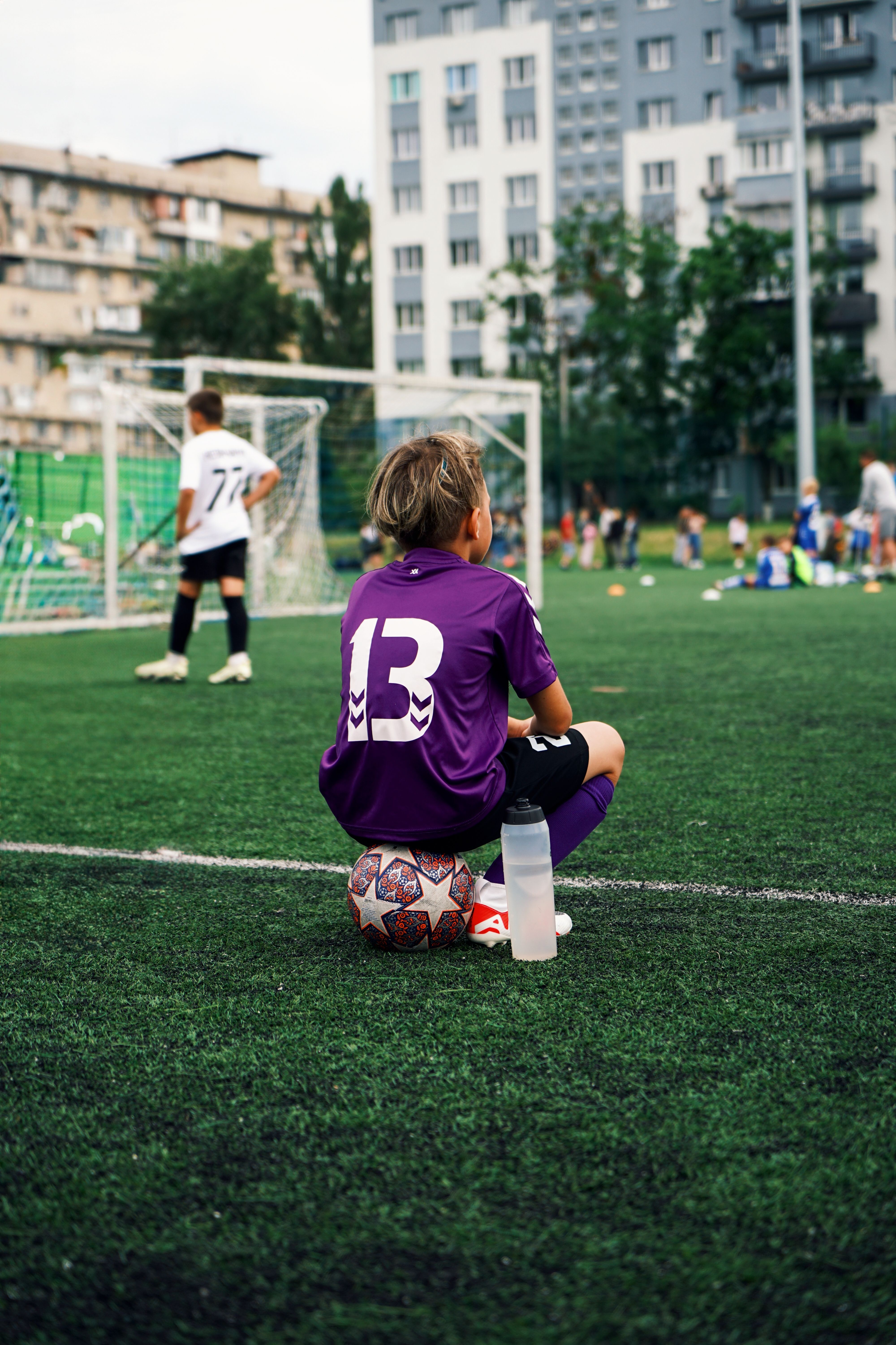 Soccer Player Sitting on Ball · Free Stock Photo