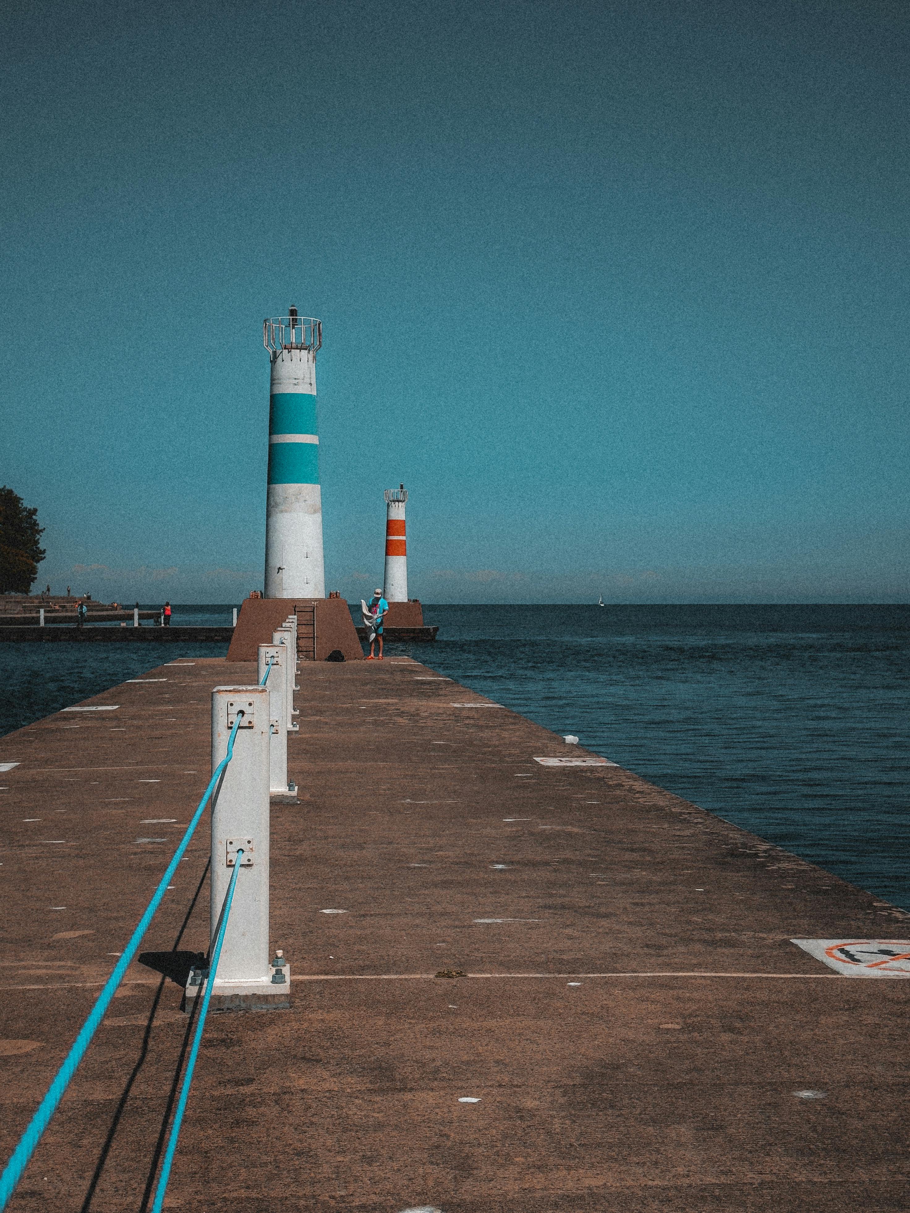 A pier with two lighthouses on it · Free Stock Photo