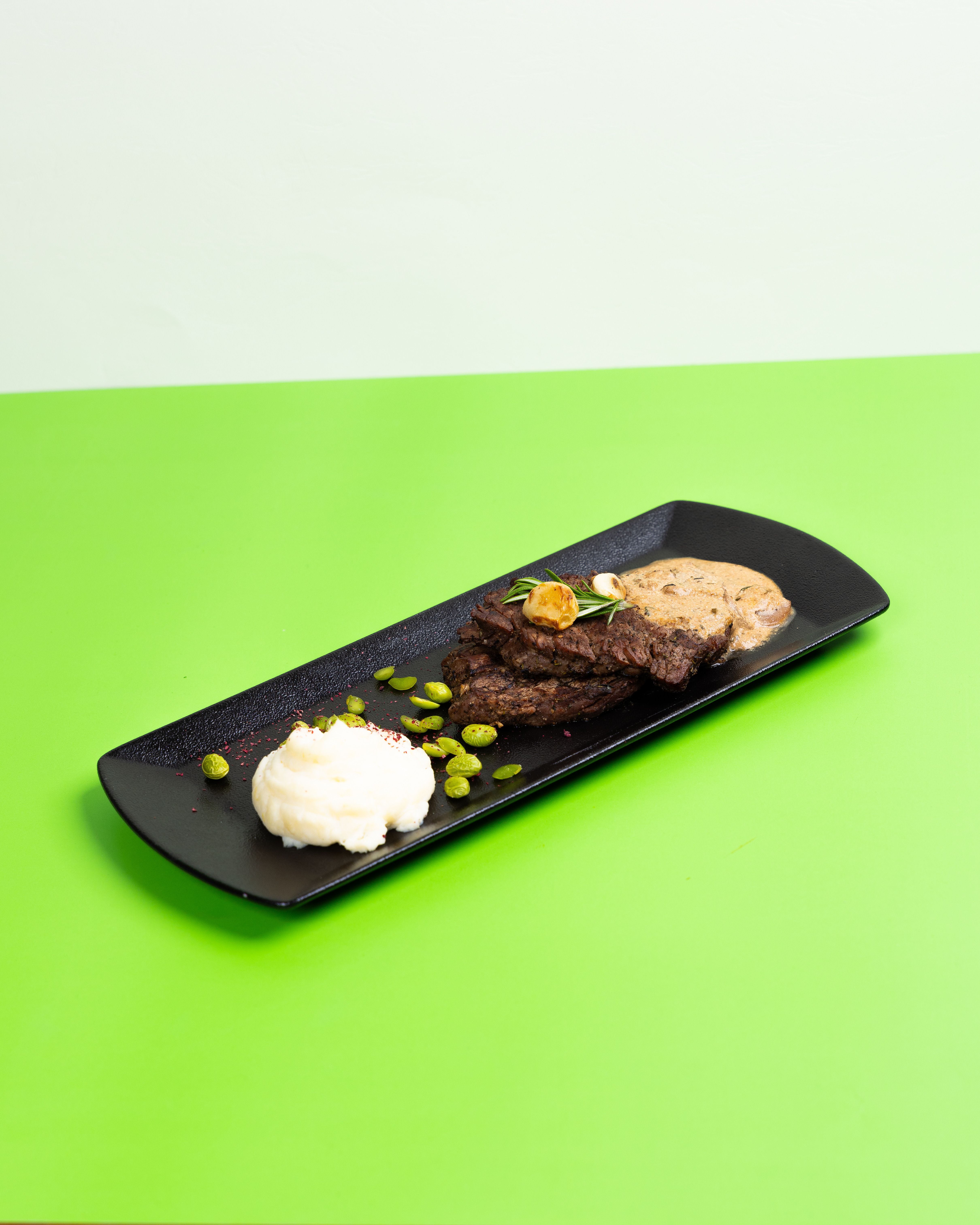 Meat with Sauce and Mashed Potatoes on a Black Tray · Free Stock Photo