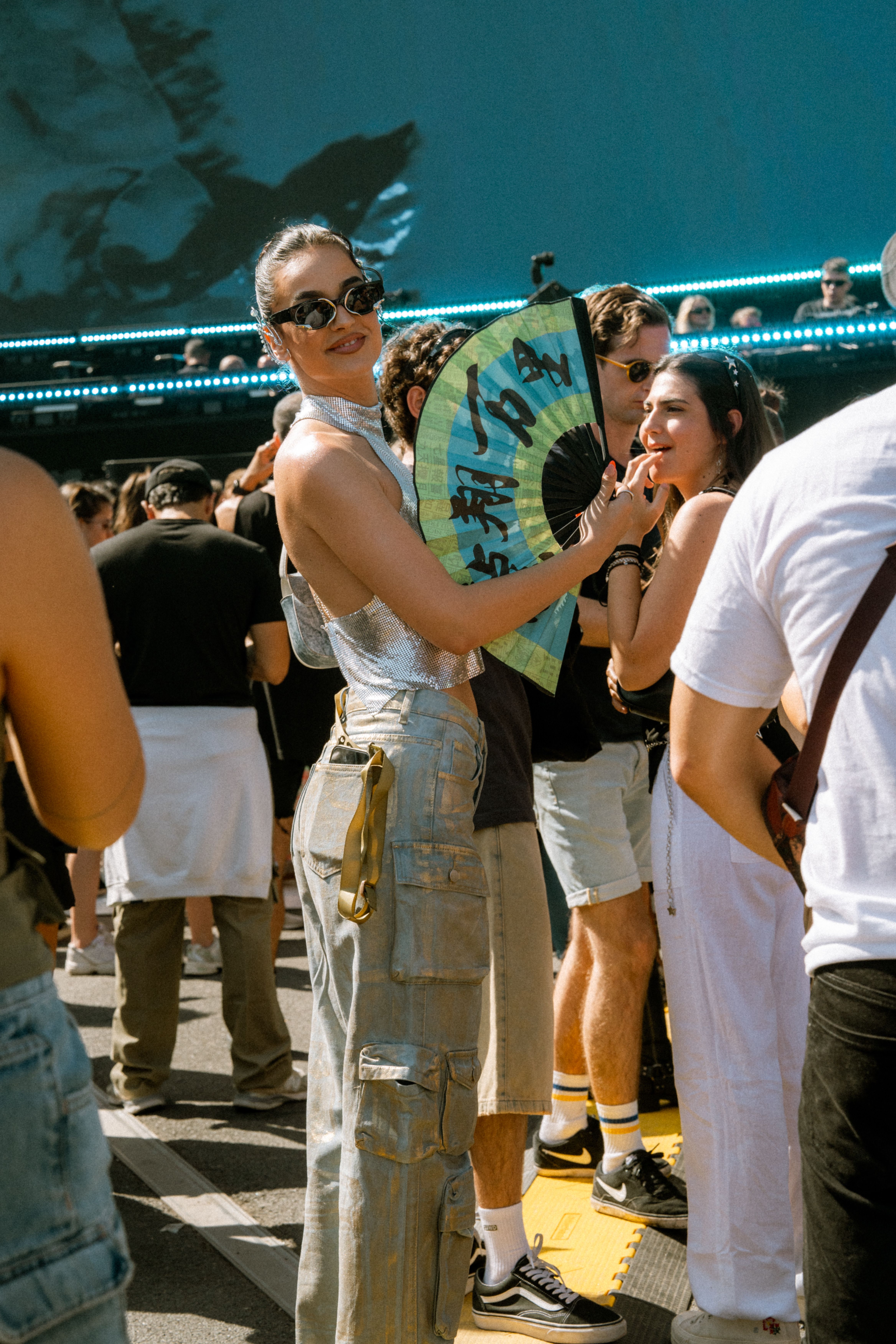 A woman in a silver outfit holding a fan · Free Stock Photo