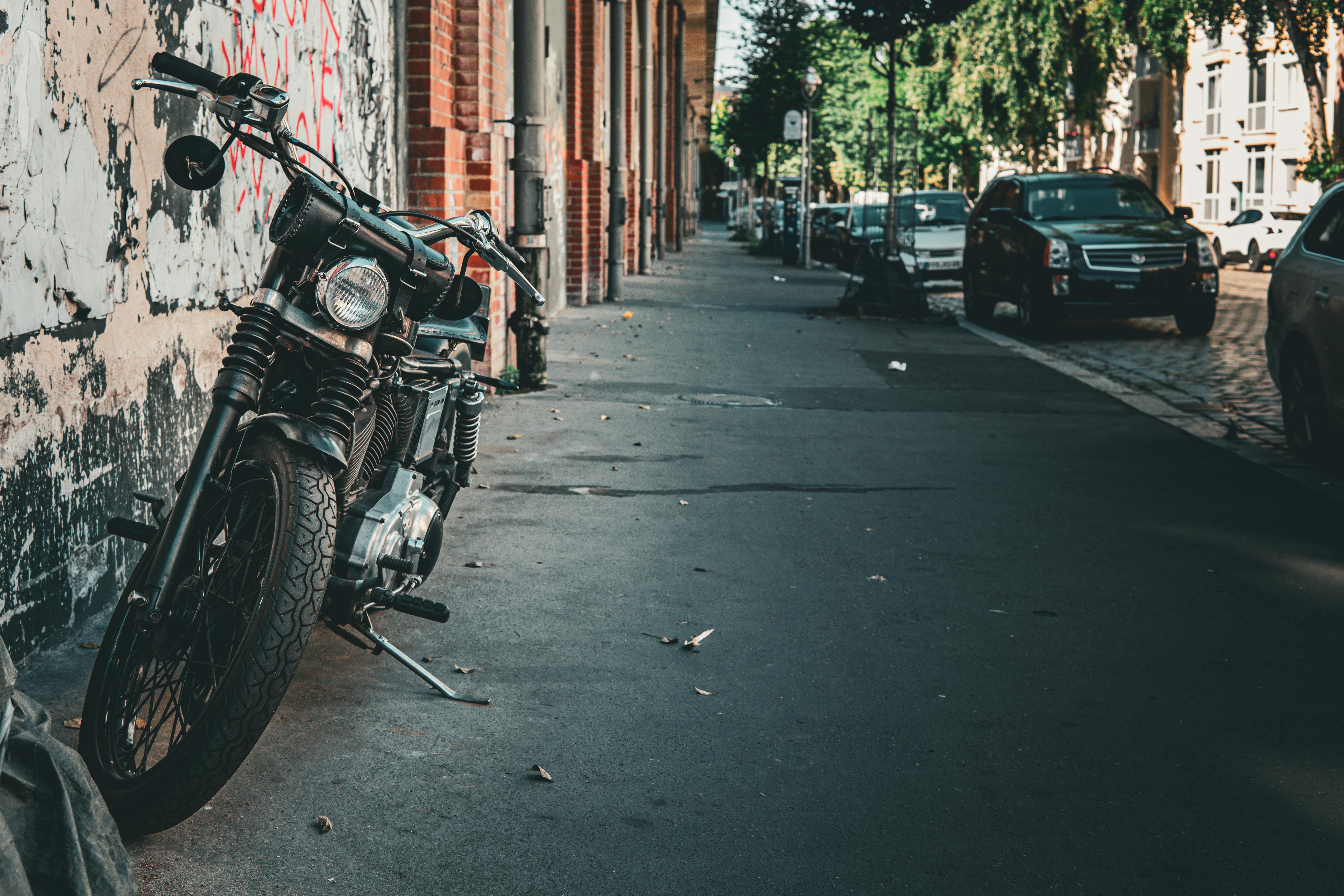 Vintage Black Motorcycle Parked on Side of Pavement · Free Stock Photo