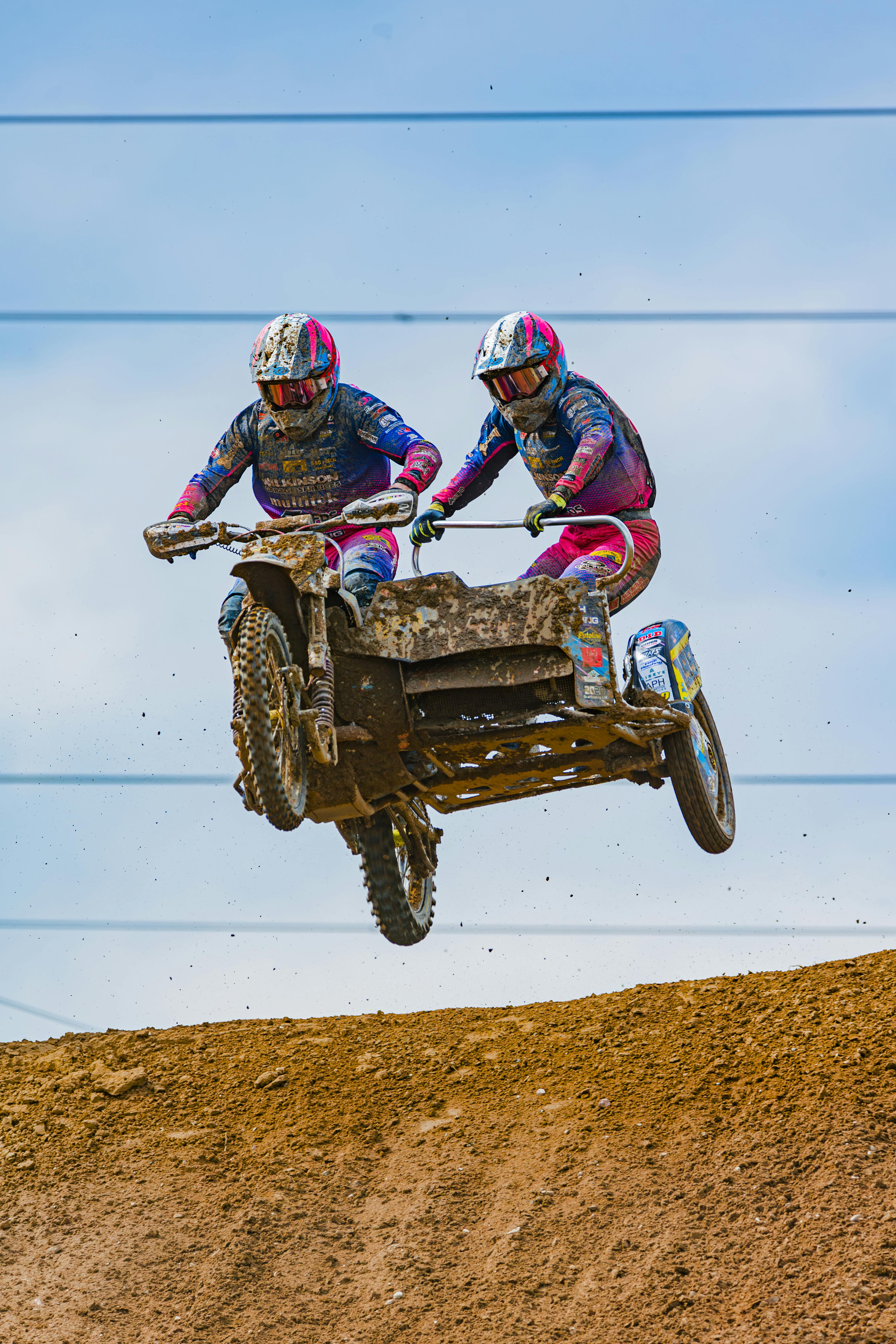 Sidecarcross Bikers in Midair over Muddy Track · Free Stock Photo