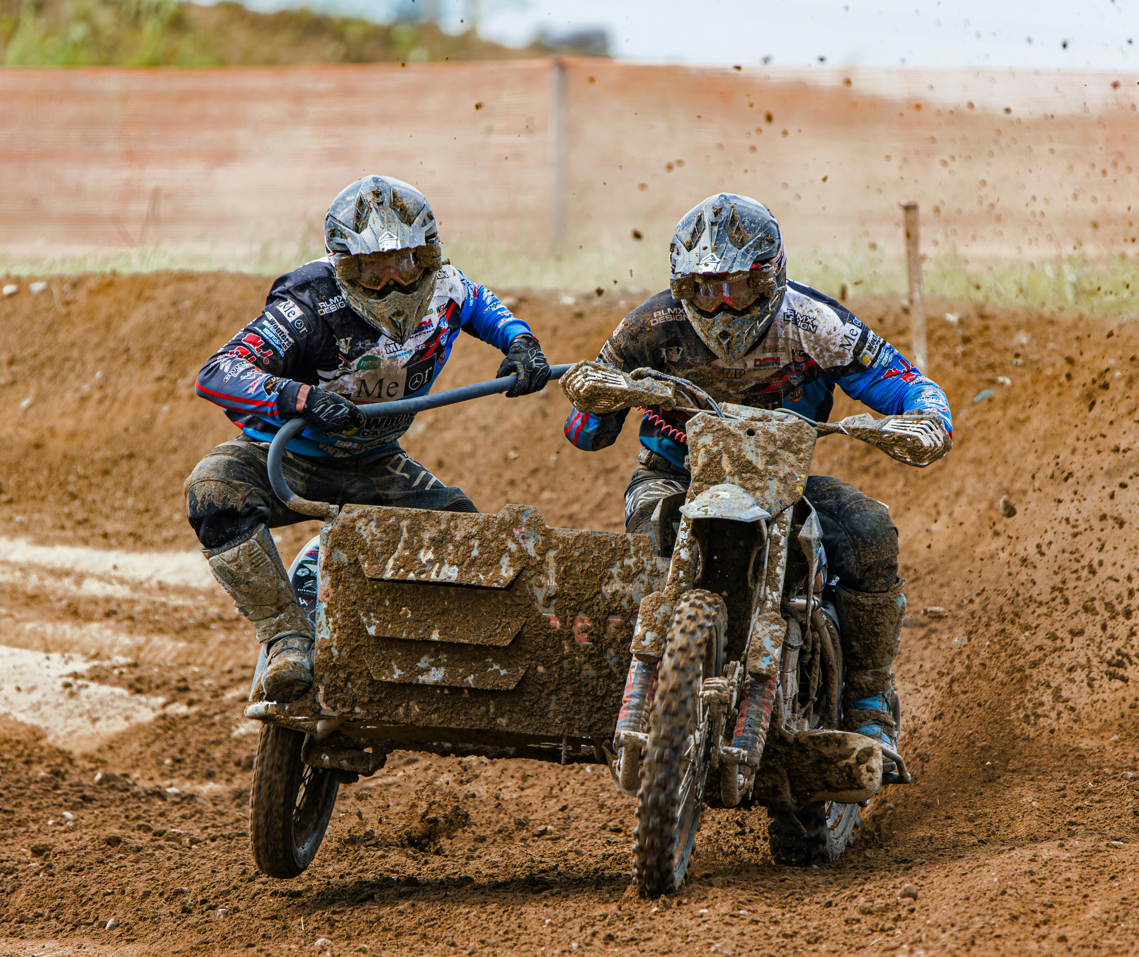 Two people riding dirt bikes on a muddy track · Free Stock Photo