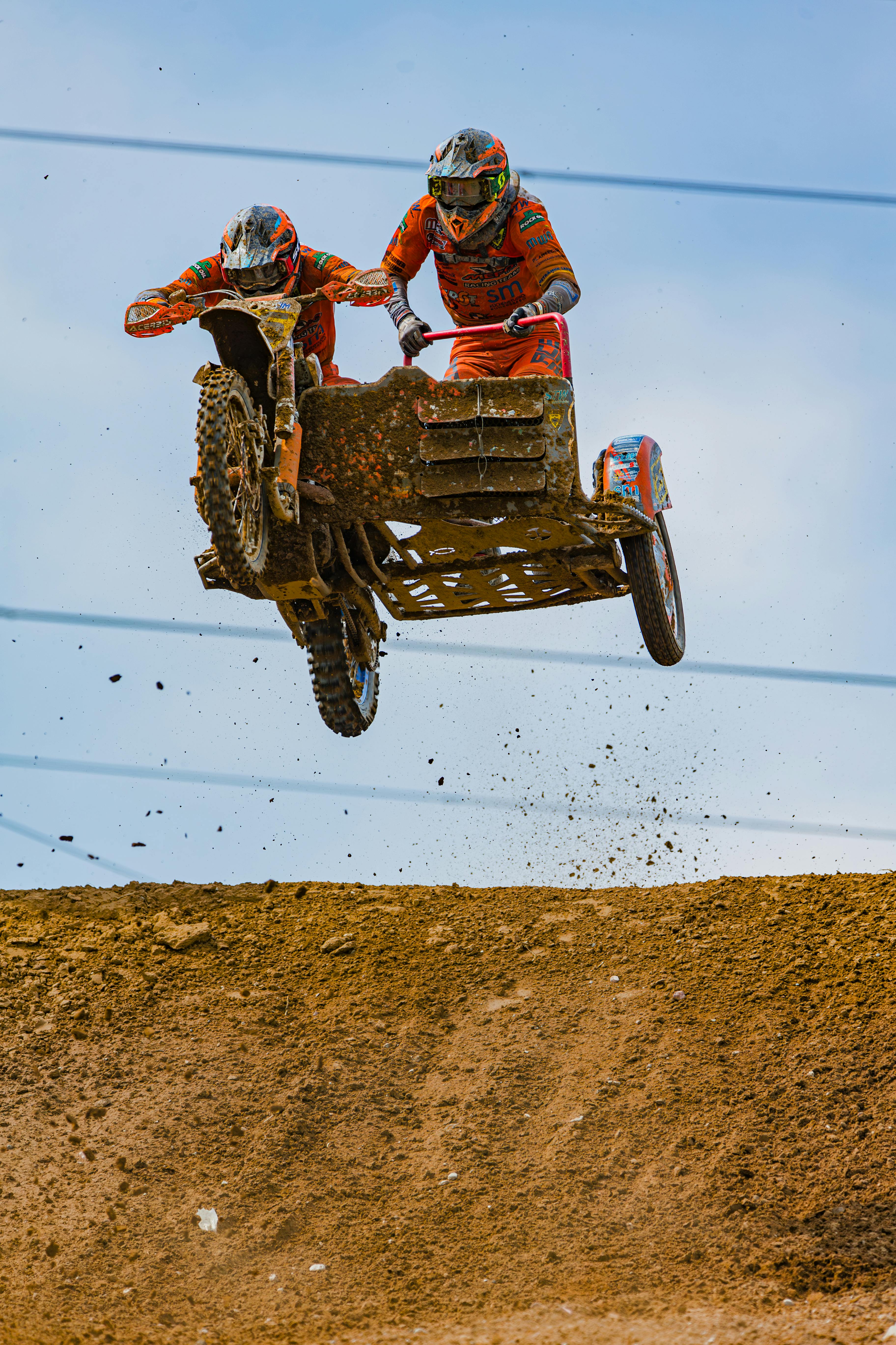 Sidecarcross Bikers in Mid Air over Muddy Track · Free Stock Photo