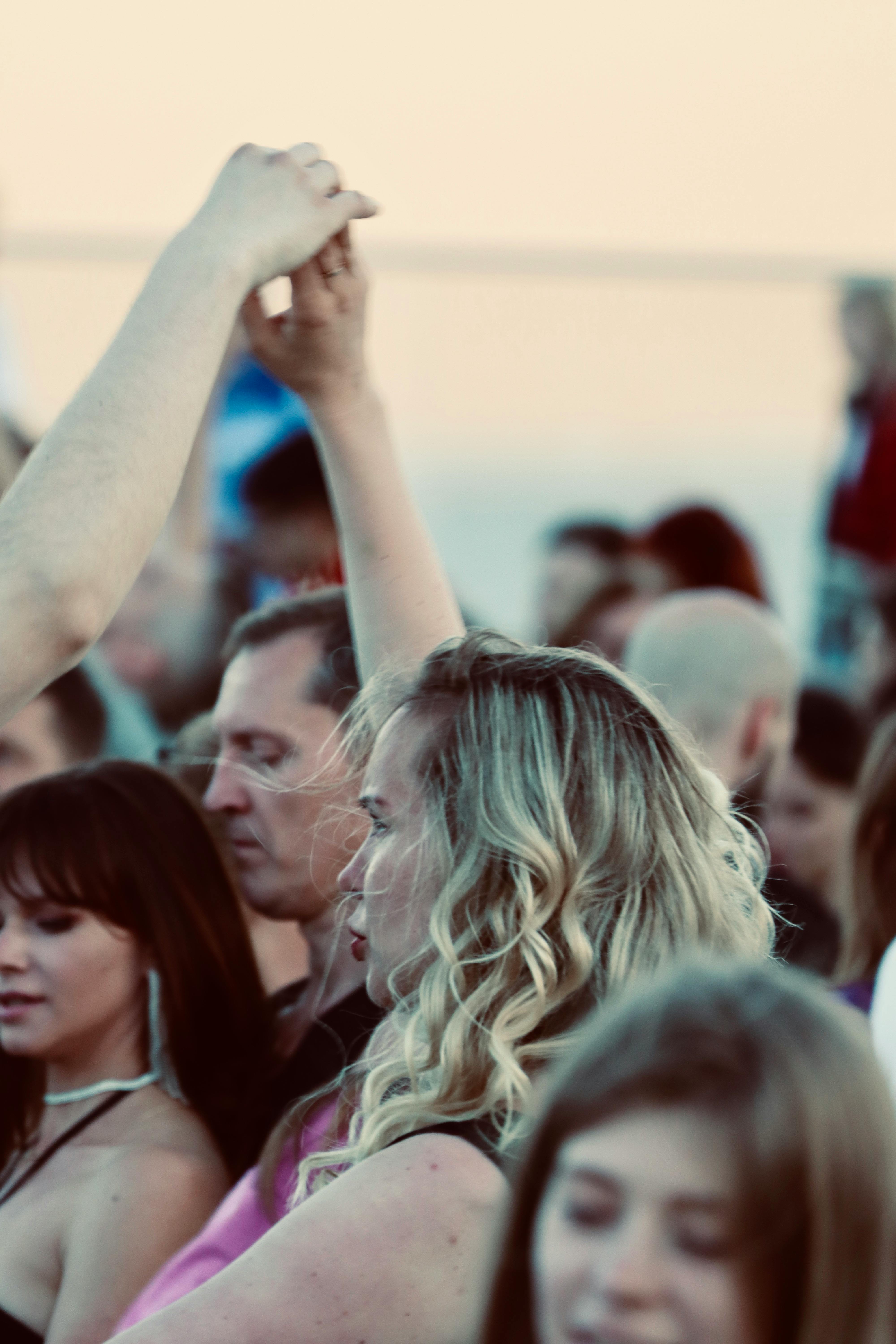 Side View of Blonde Woman in Crowd of People · Free Stock Photo