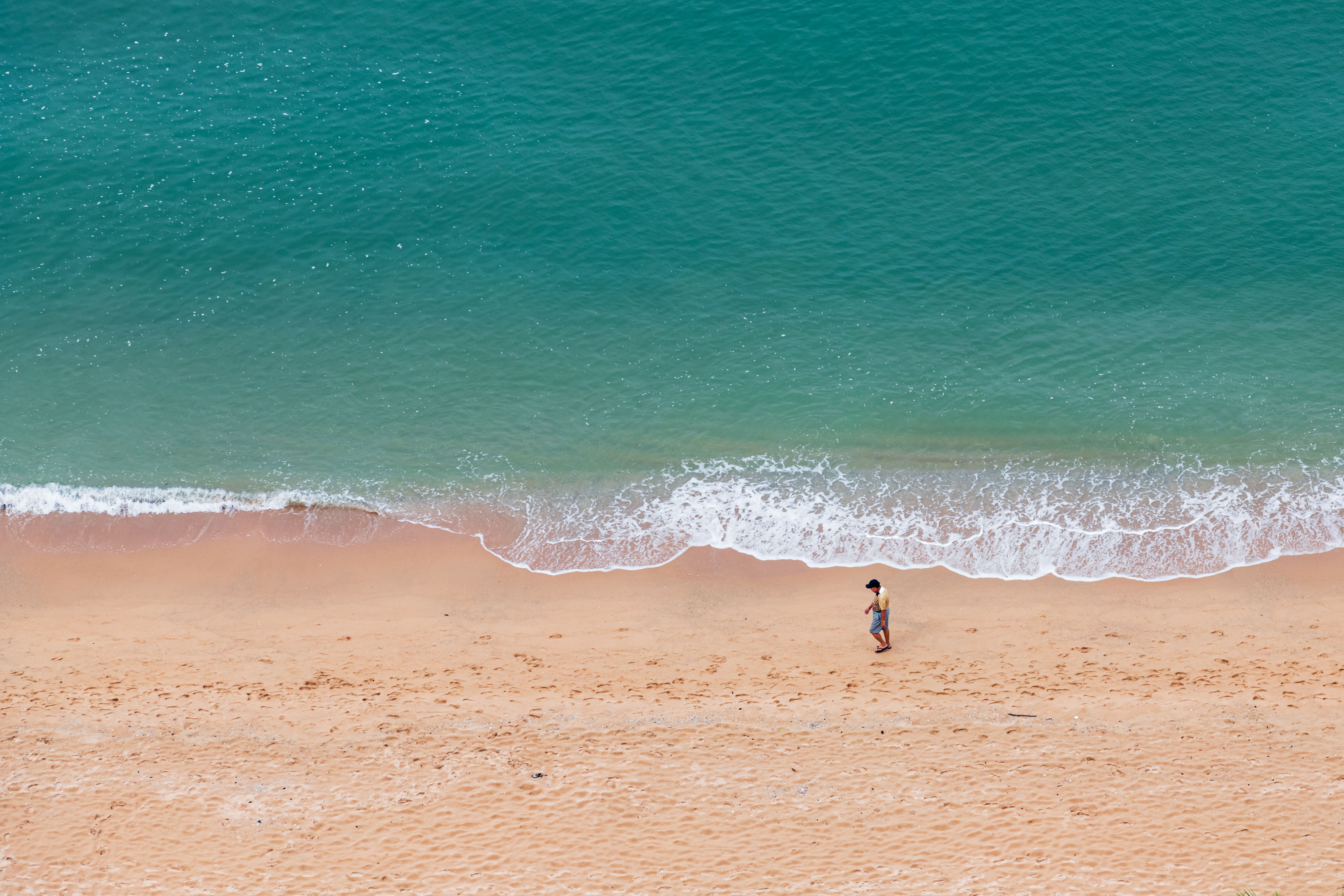 Aerial View of a Tourist Walking on the Beach · Free Stock Photo