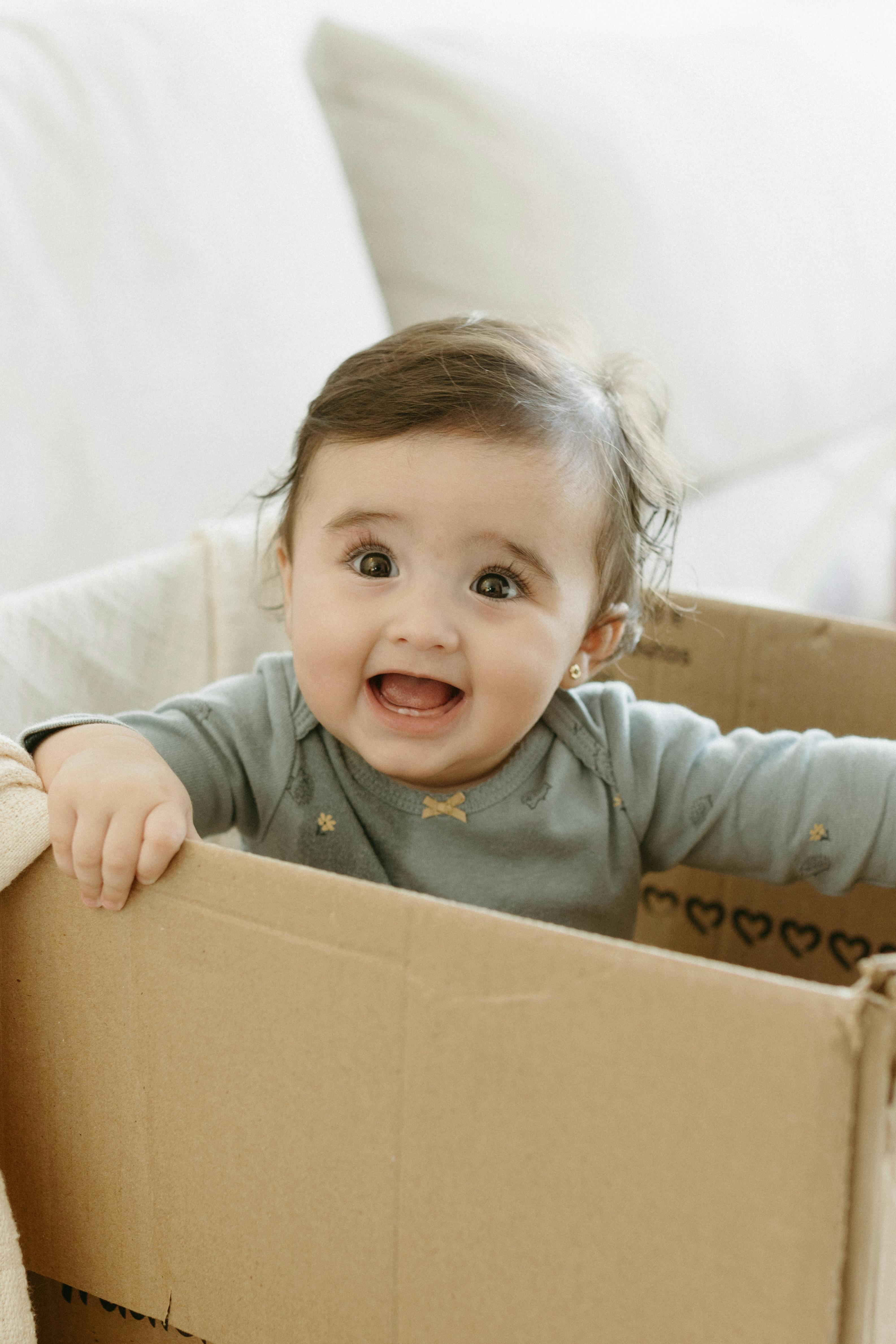 Enthusiastic Baby in Cardboard Box · Free Stock Photo