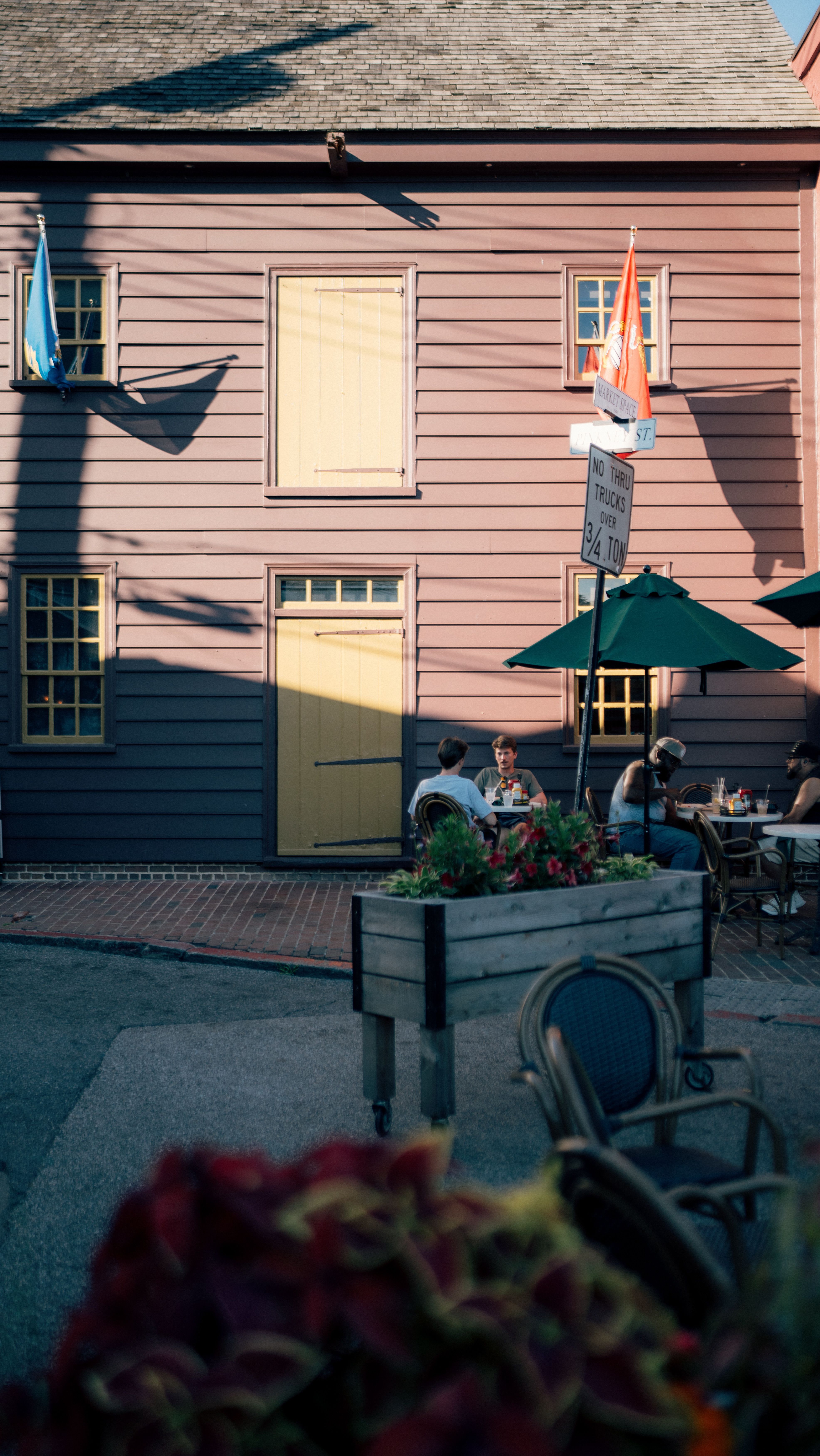 People Eating and Relaxing Outside a Wooden Building · Free Stock Photo