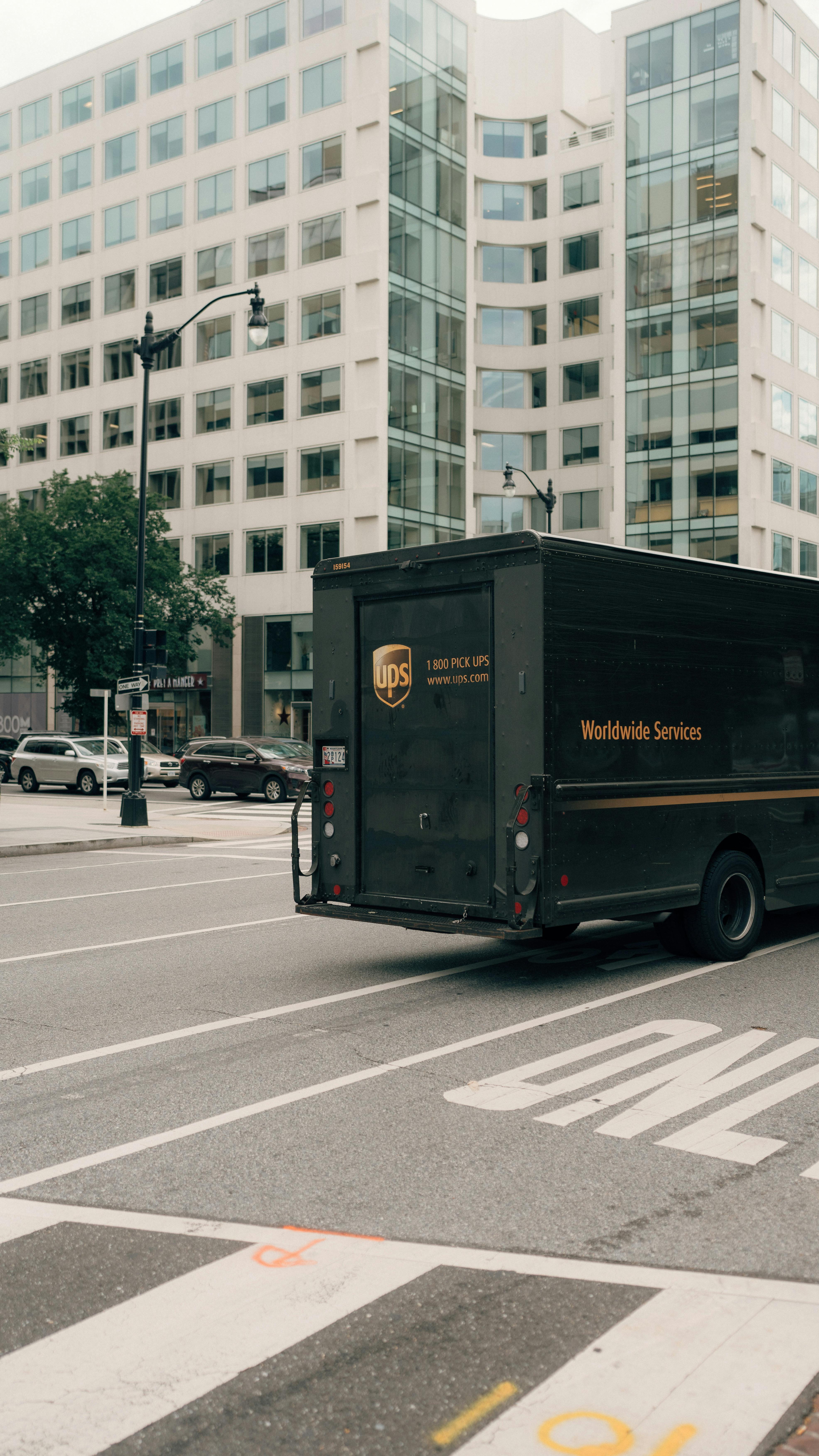 A ups truck driving down a city street · Free Stock Photo