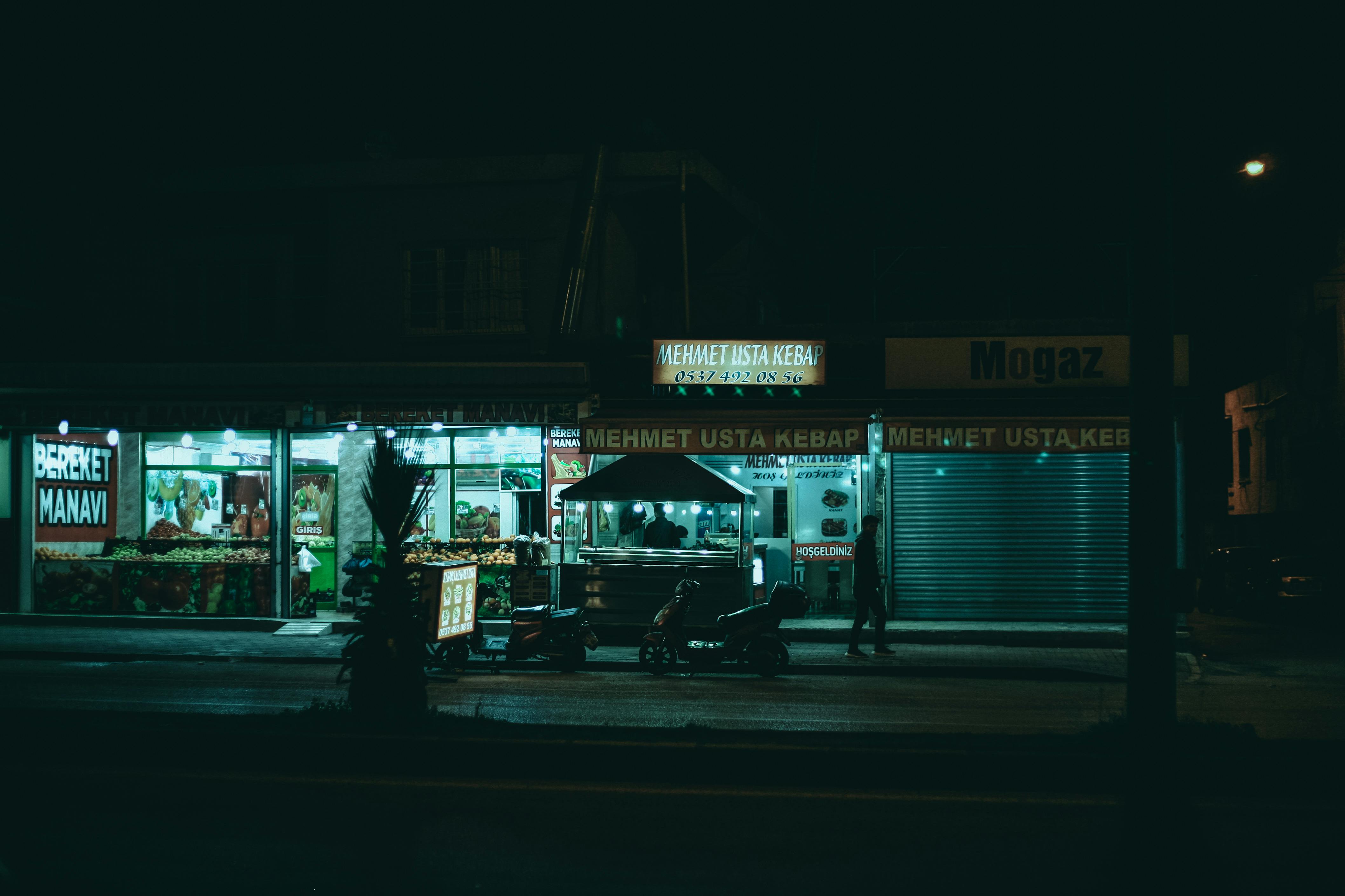 A street scene at night with a store and people · Free Stock Photo