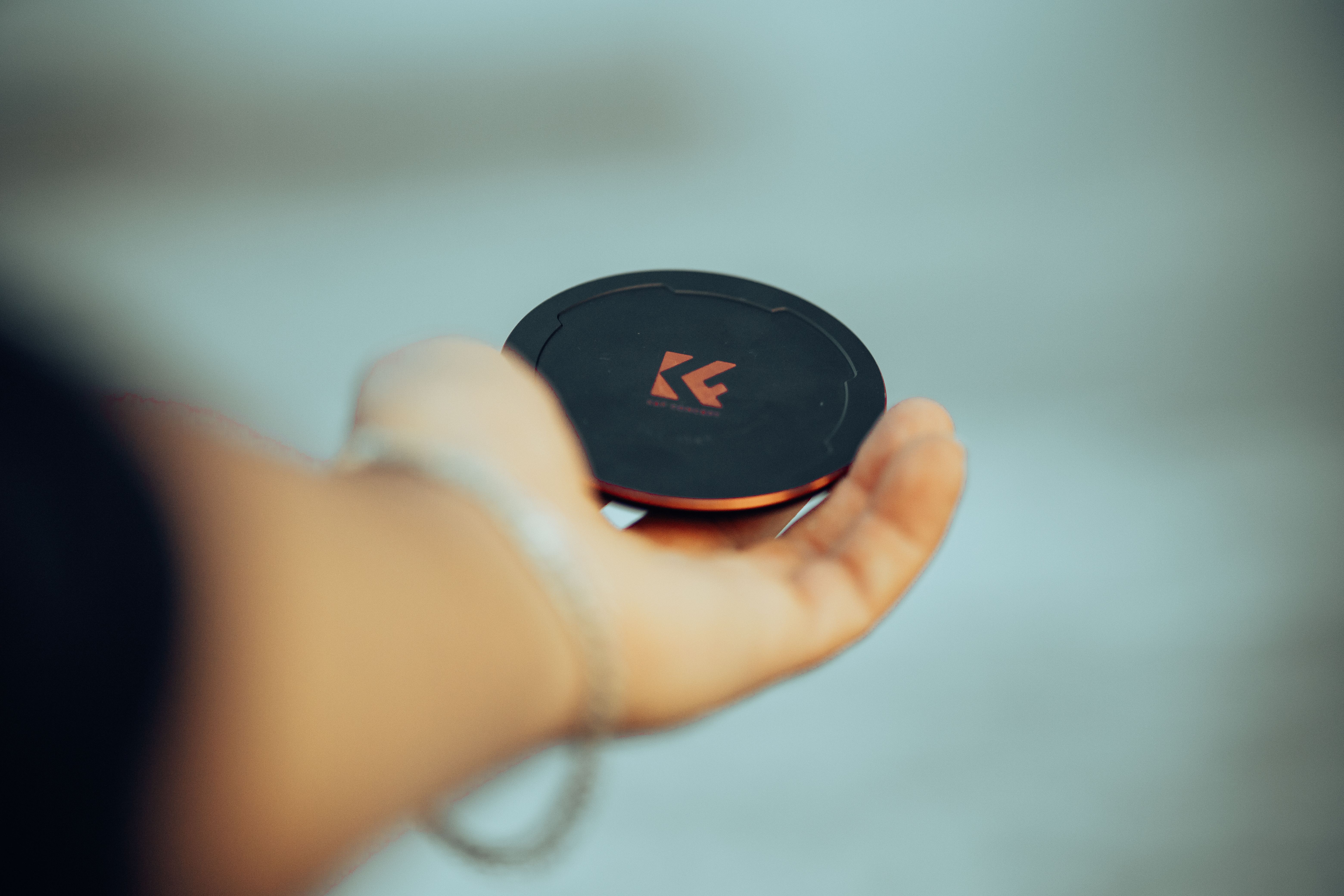 A person holding a small black and red device · Free Stock Photo