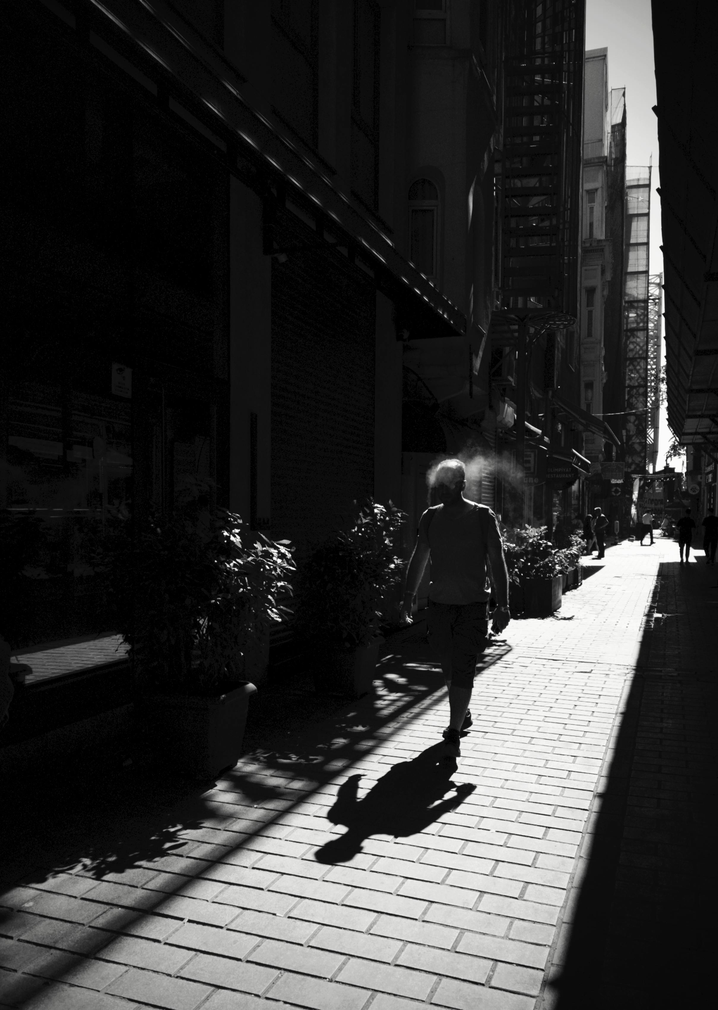 Silhouette of Person Walking in Alley between Buildings Smoking · Free ...