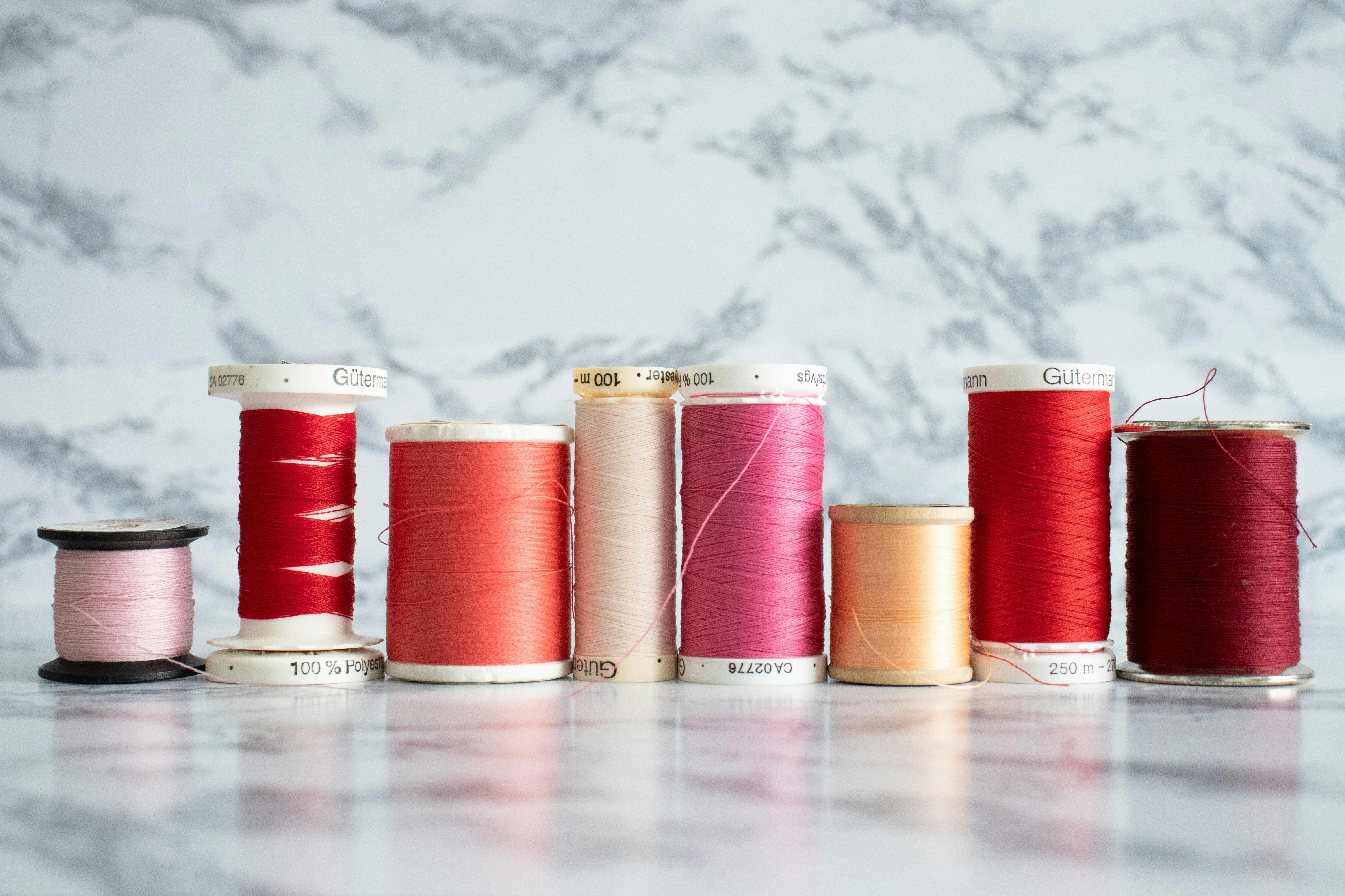 Sewing Threads on a White Surface · Free Stock Photo