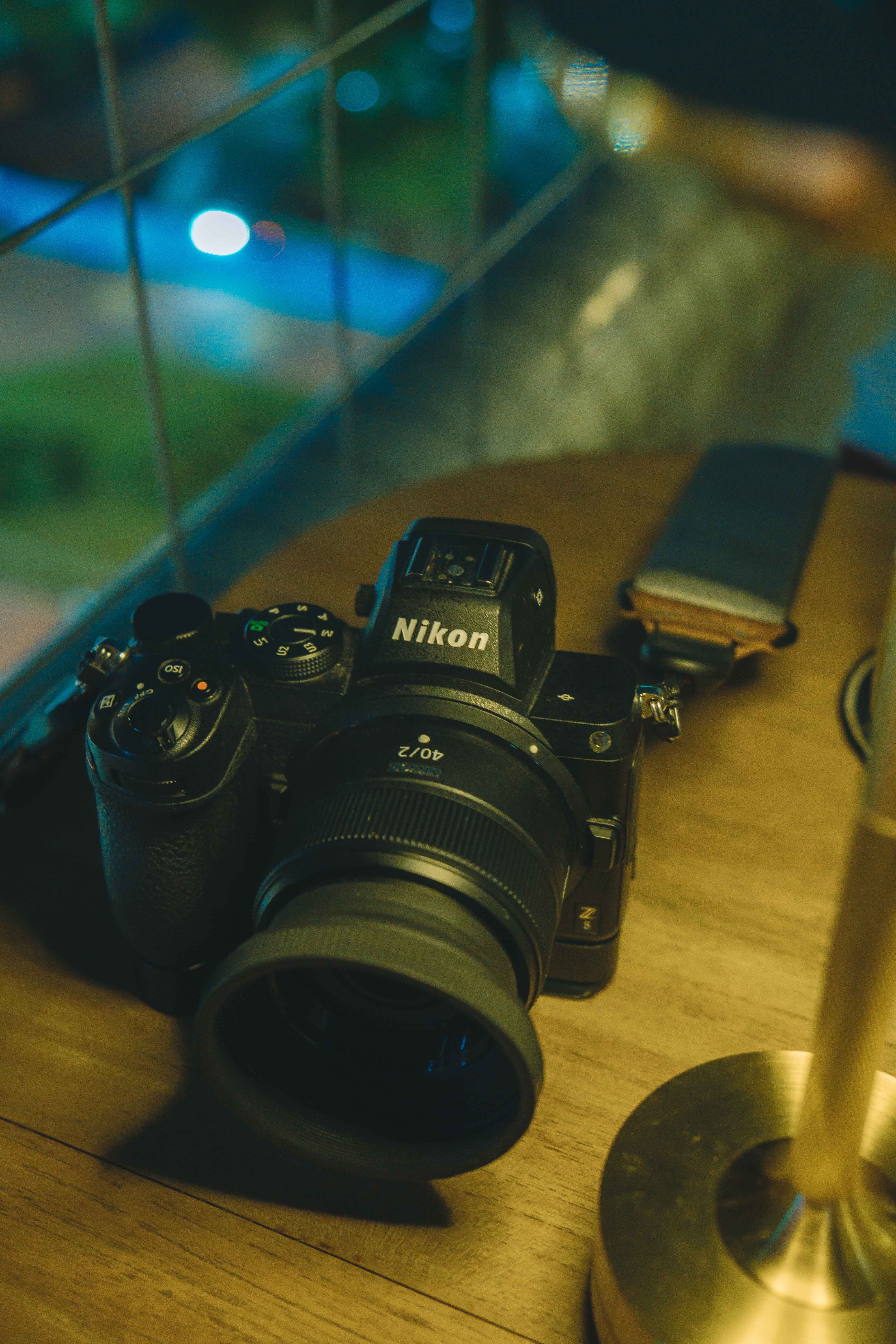 A camera sitting on a table next to a lamp · Free Stock Photo