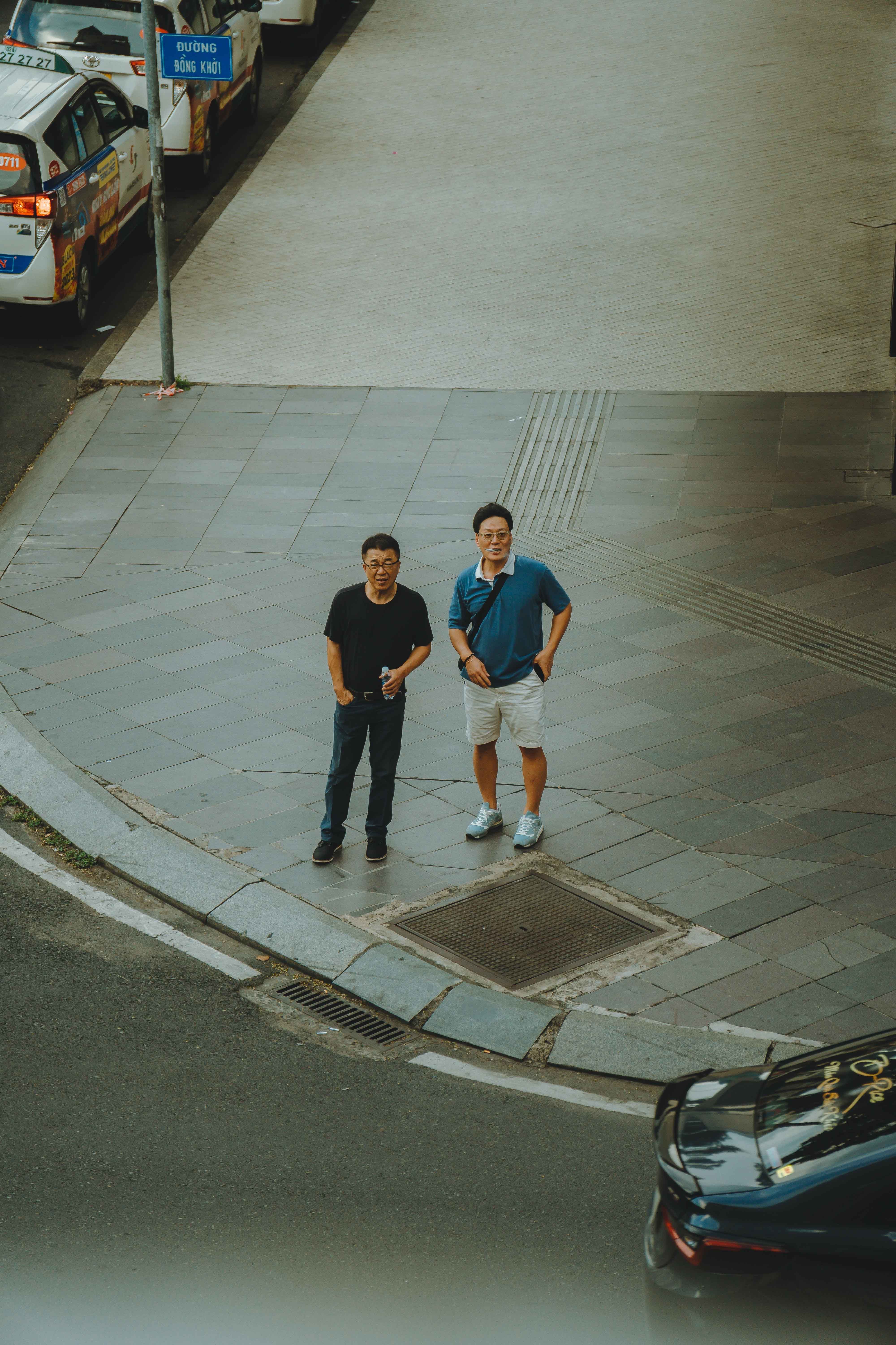 Two men standing on the street in front of a bus · Free Stock Photo