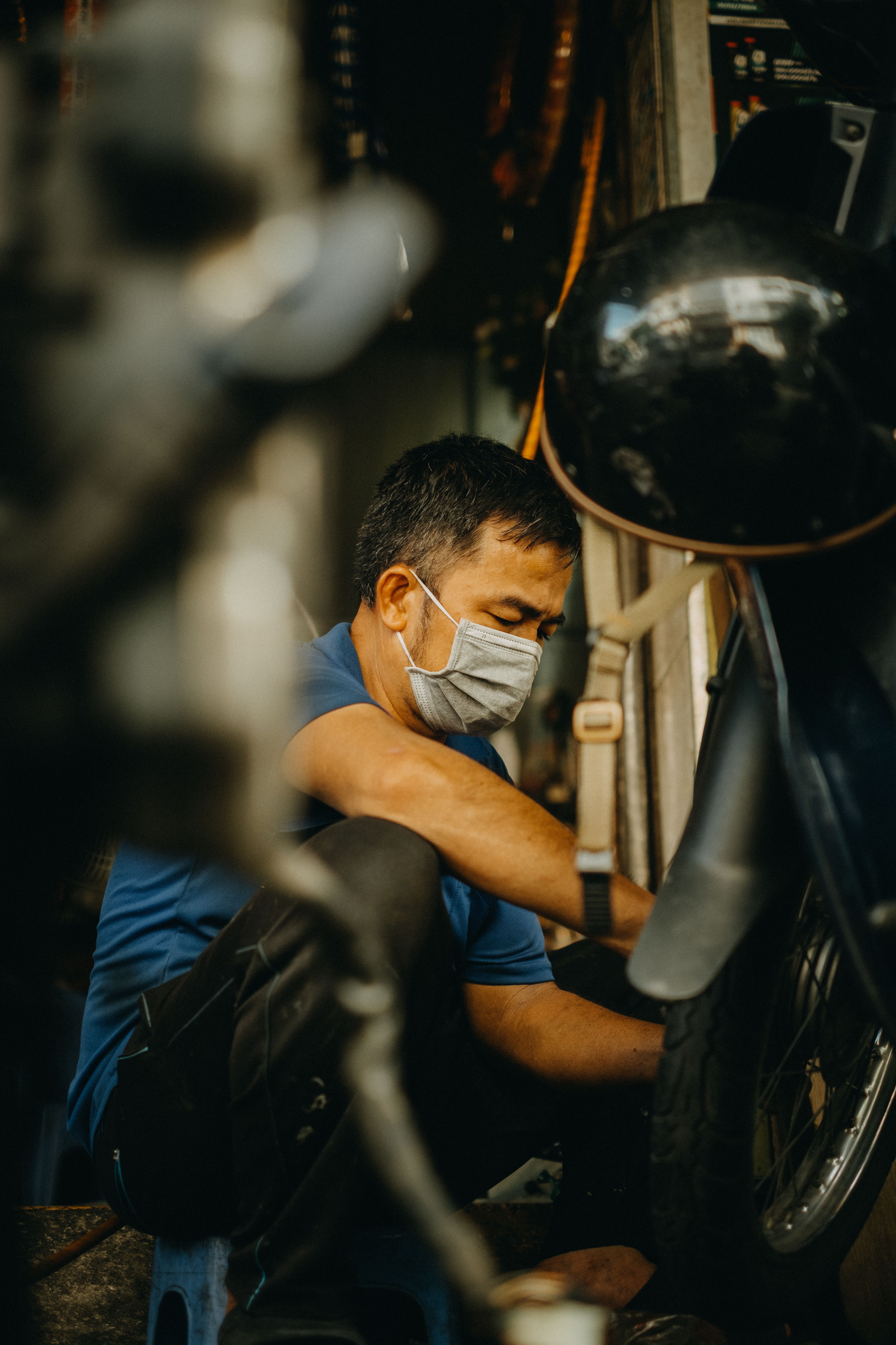 Mechanic Sitting in Mask and Working · Free Stock Photo
