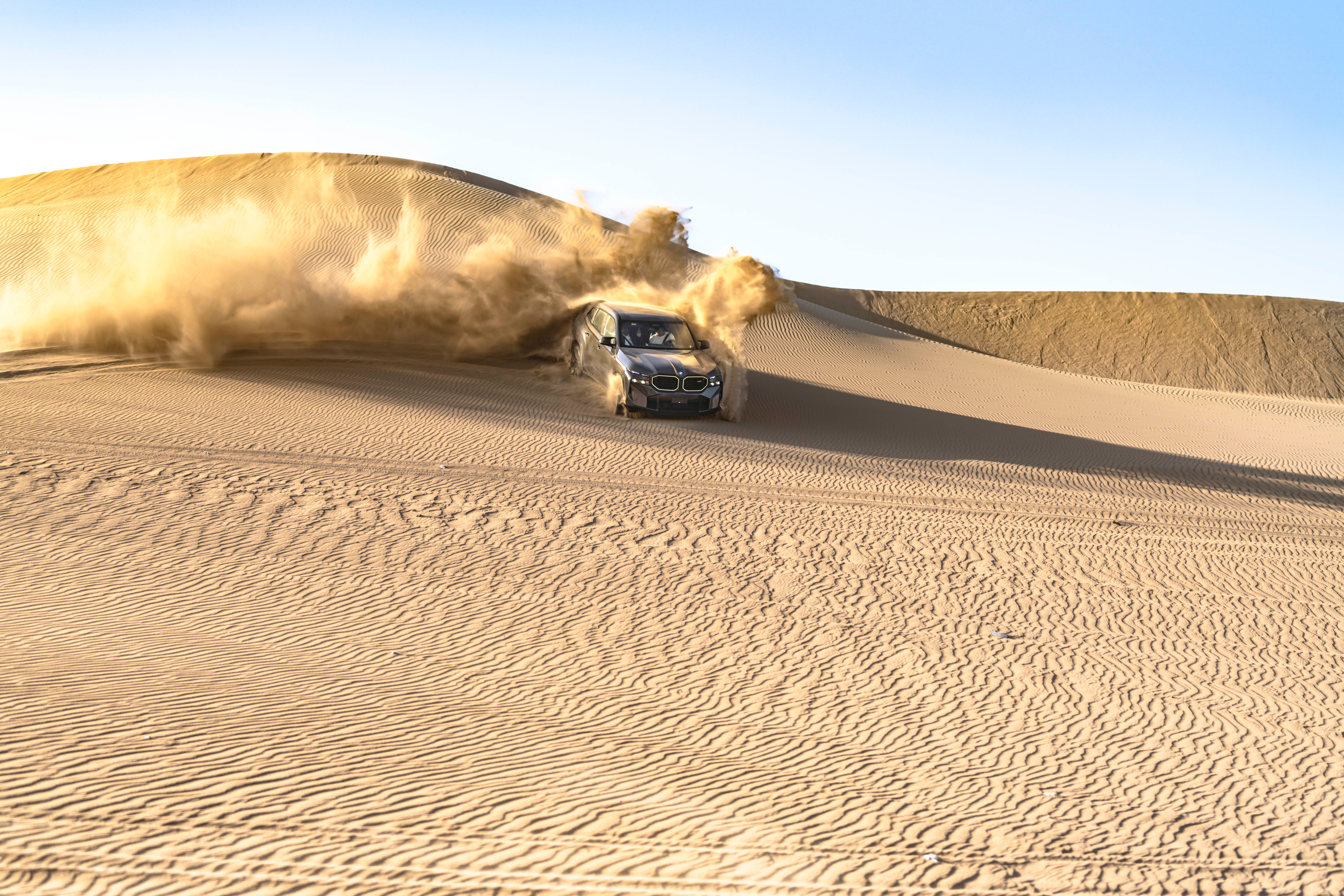 A car driving through the desert with sand blowing in the air · Free ...