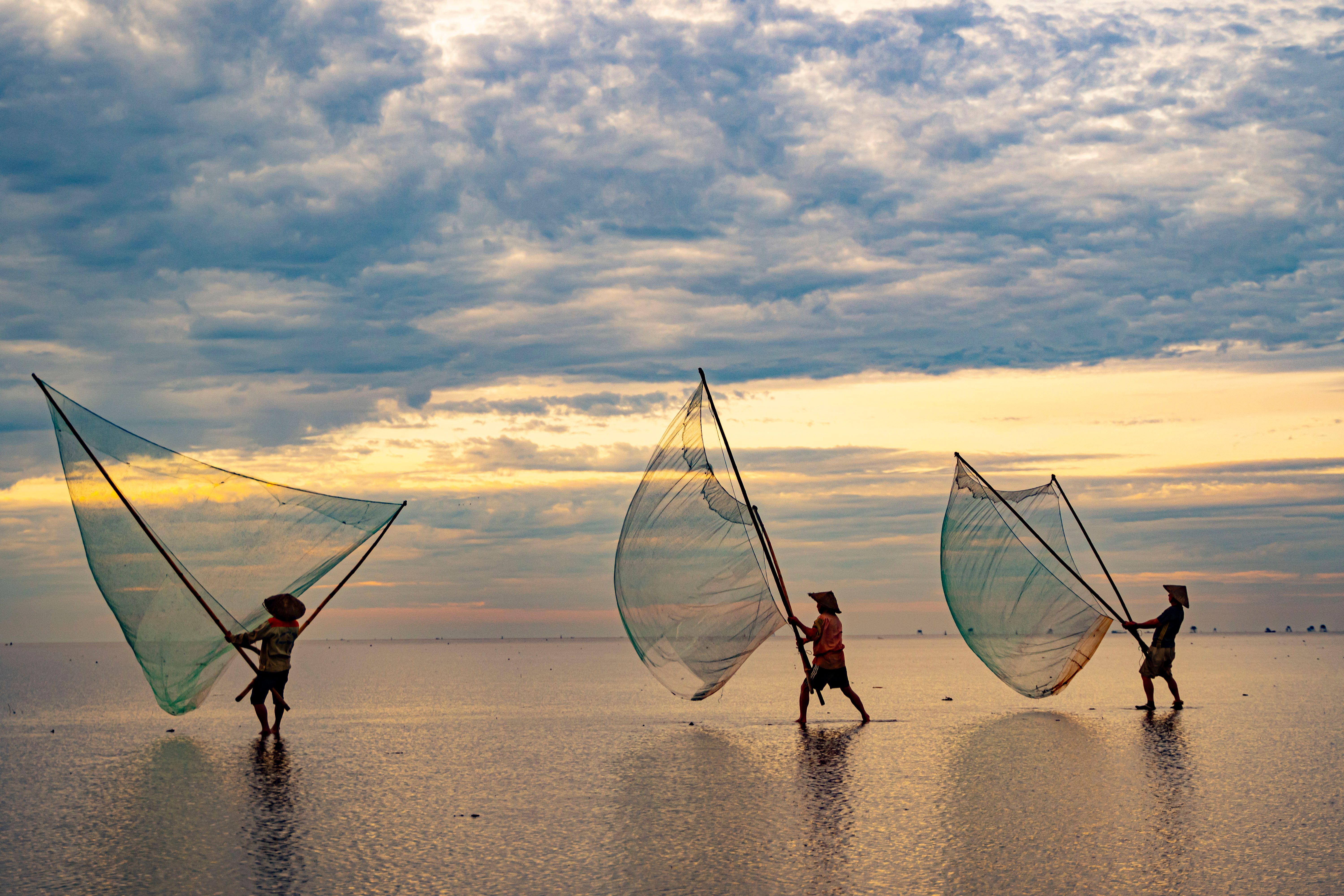 People with Fishing Nets at Dawn · Free Stock Photo