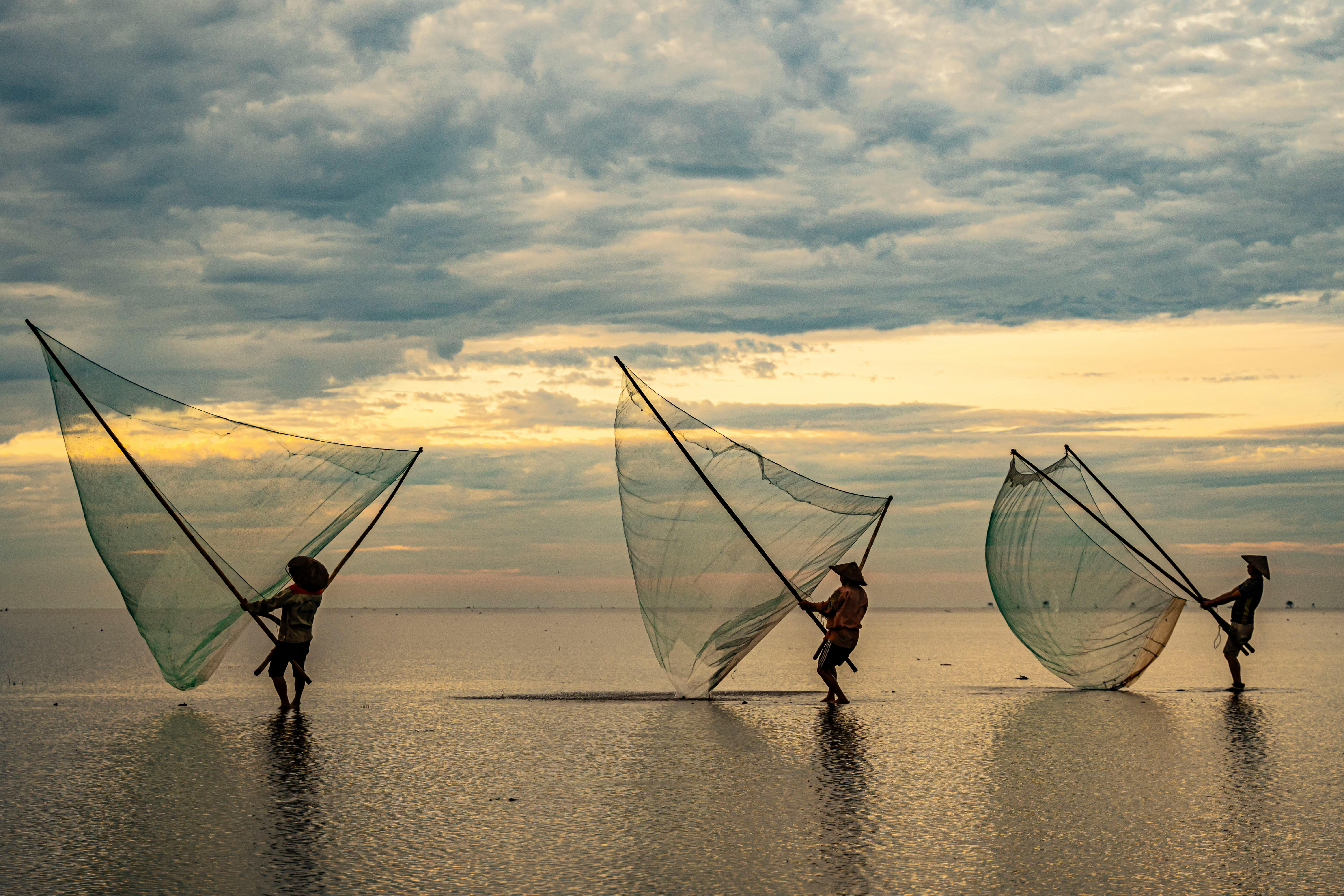People with Fishing Nets at Dawn · Free Stock Photo