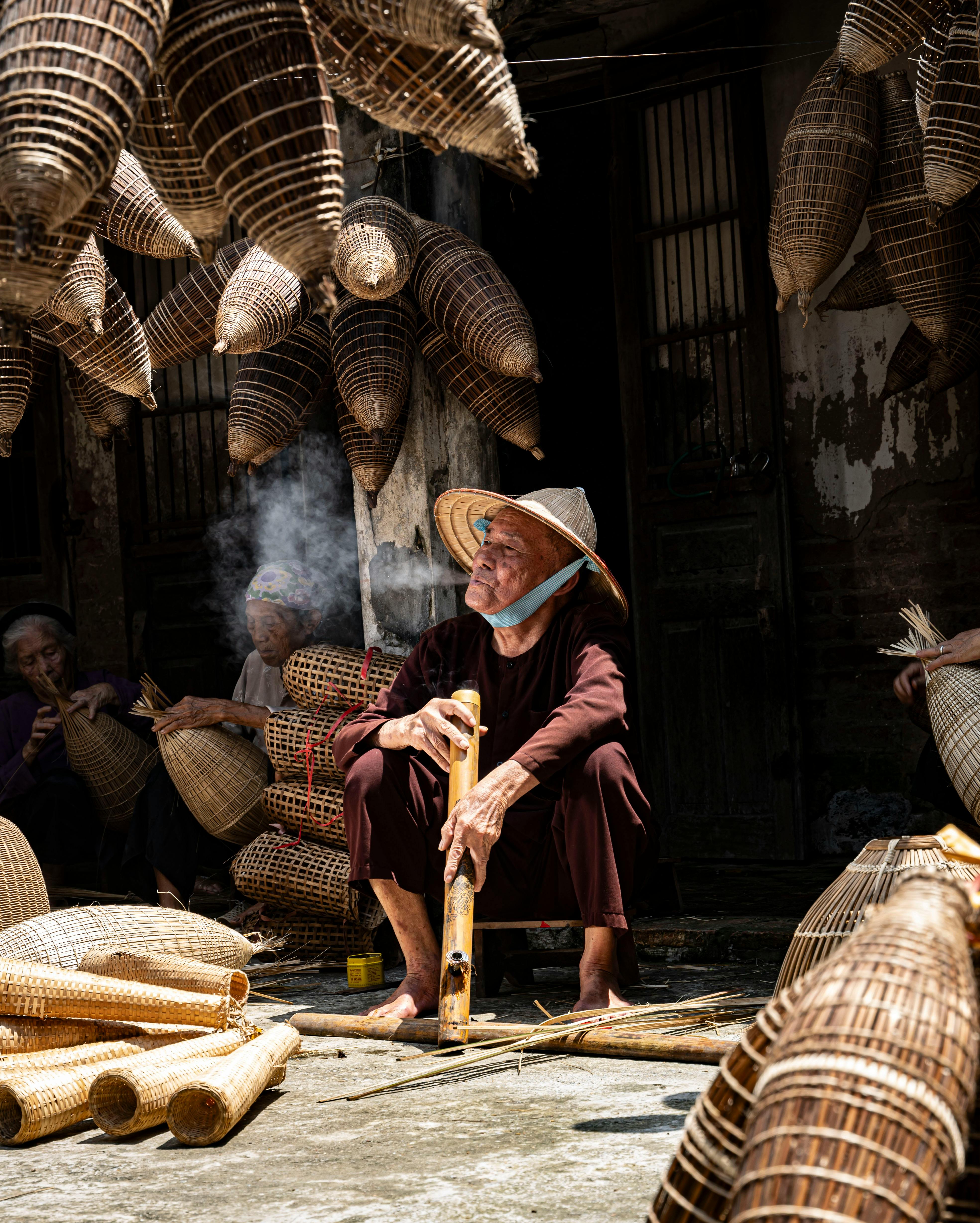 Elderly Man Sitting with Bamboo Basket and Smoking Pipe in Traditional ...