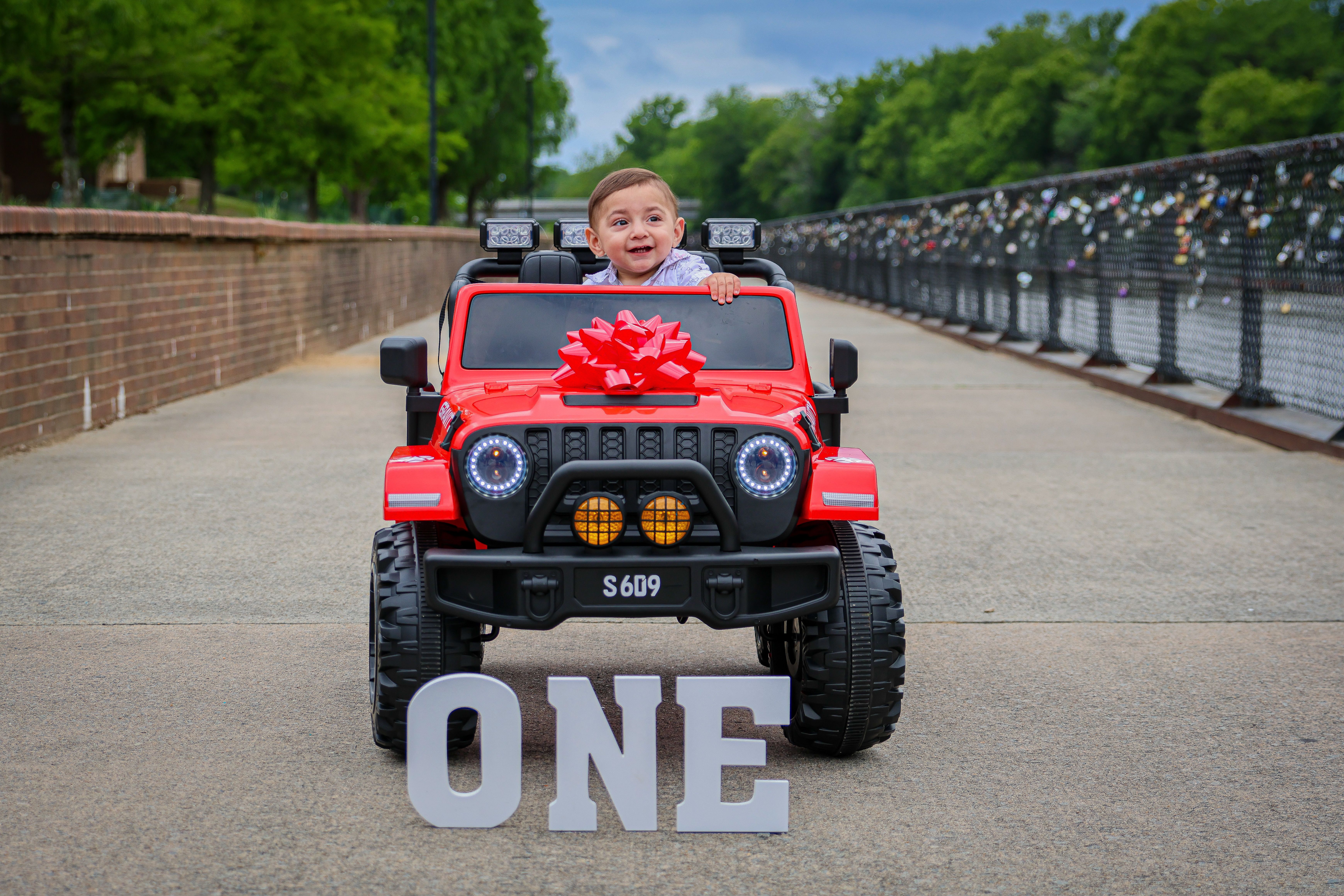 A little boy in a red jeep with a one sign · Free Stock Photo