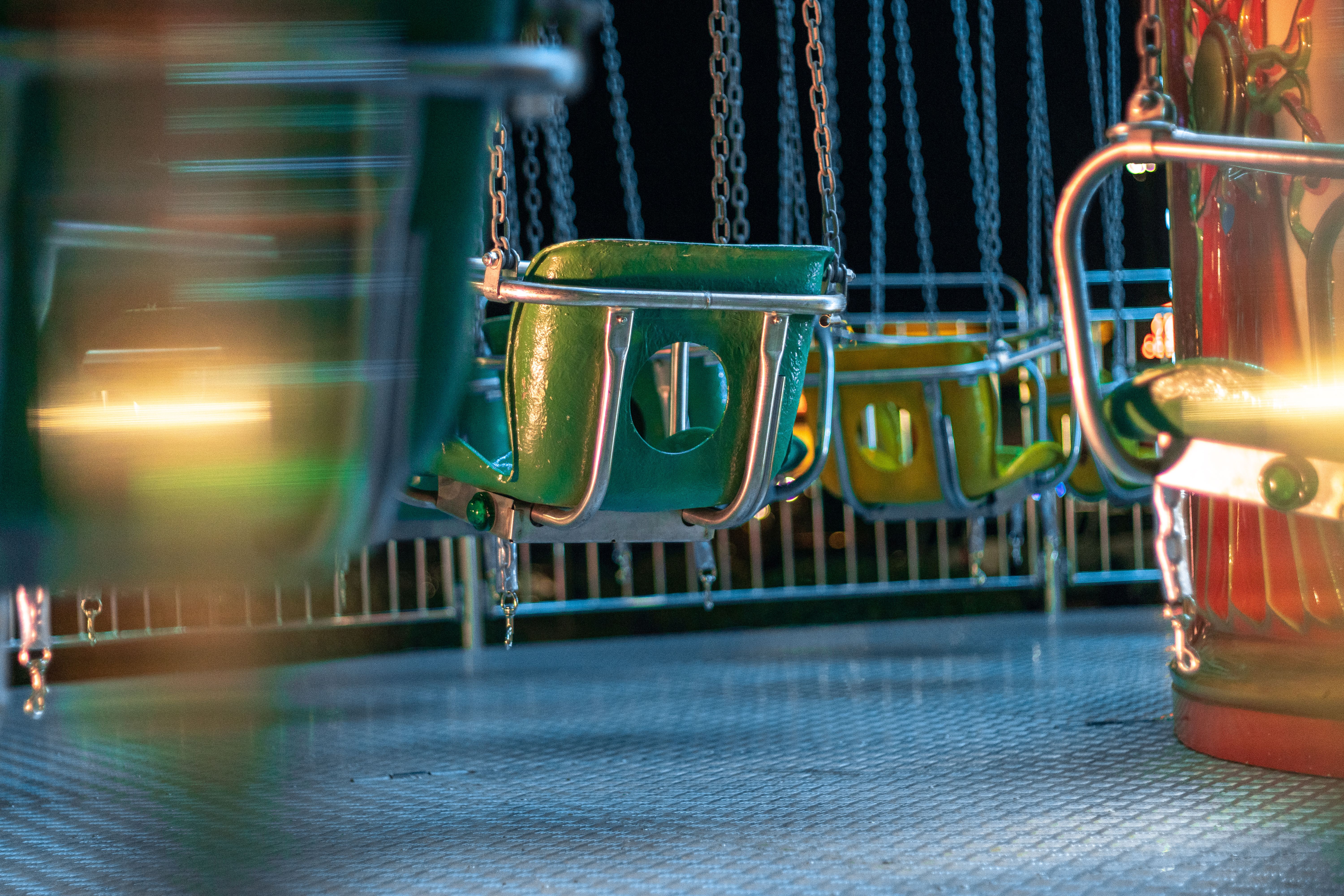 A carousel with several swings and a green light · Free Stock Photo