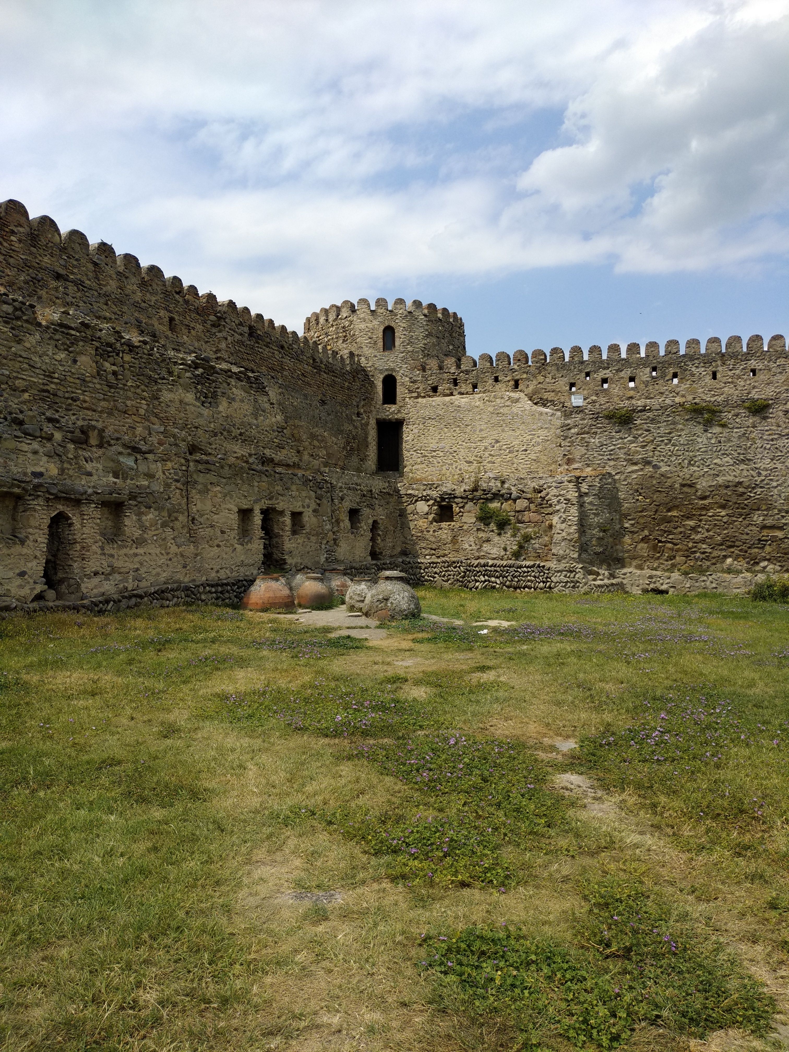 The old castle is surrounded by grass and rocks · Free Stock Photo