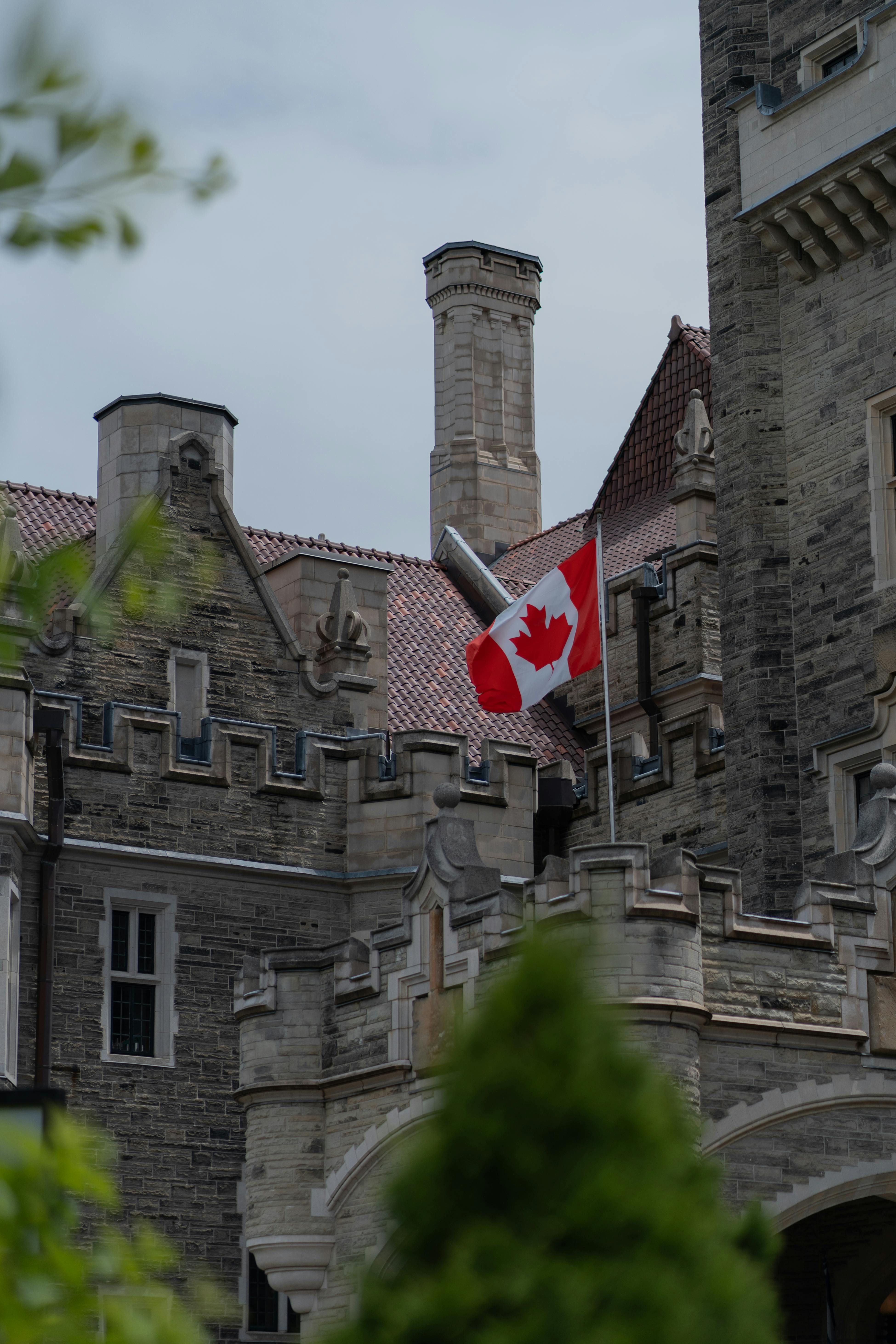 A canadian flag flying from a castle · Free Stock Photo