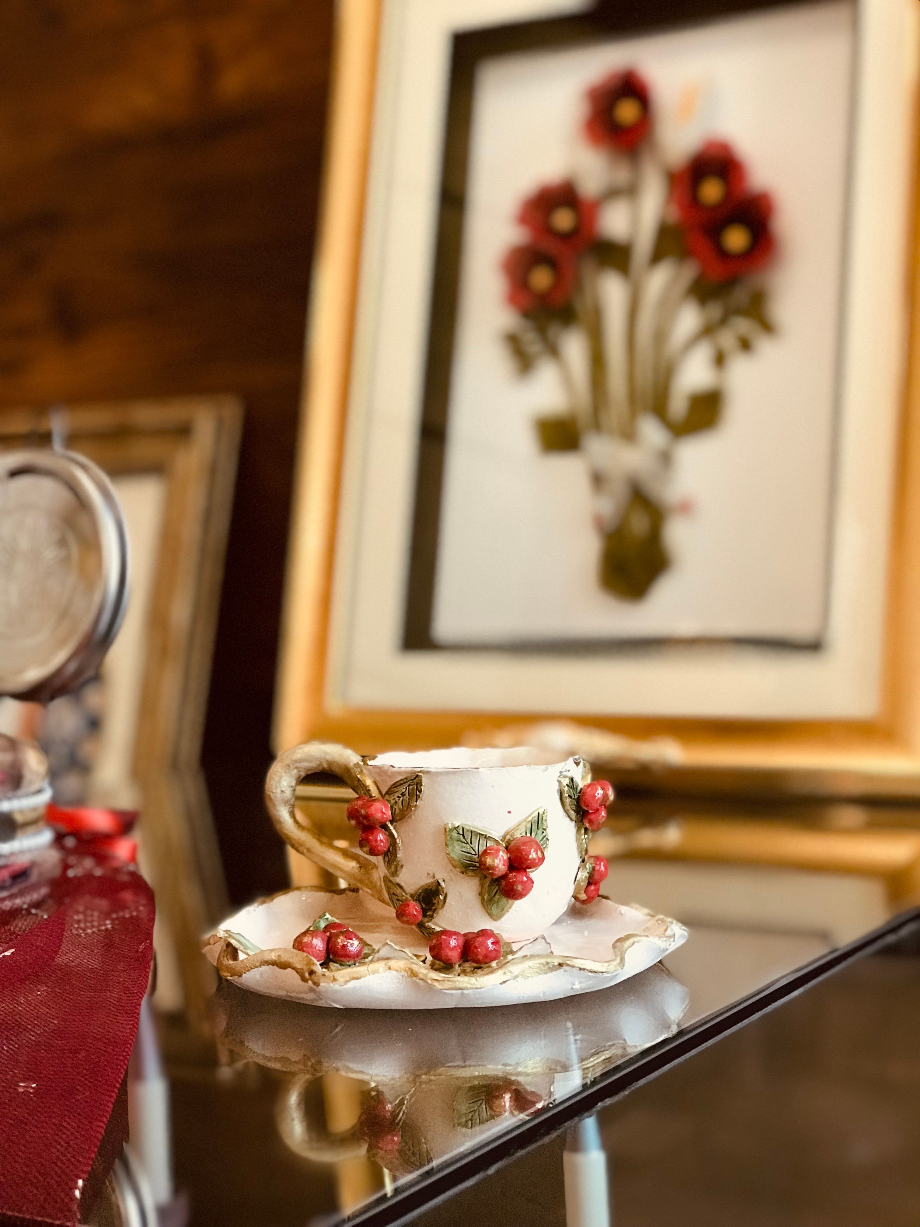 A small cup and saucer on a table next to a framed picture · Free Stock ...