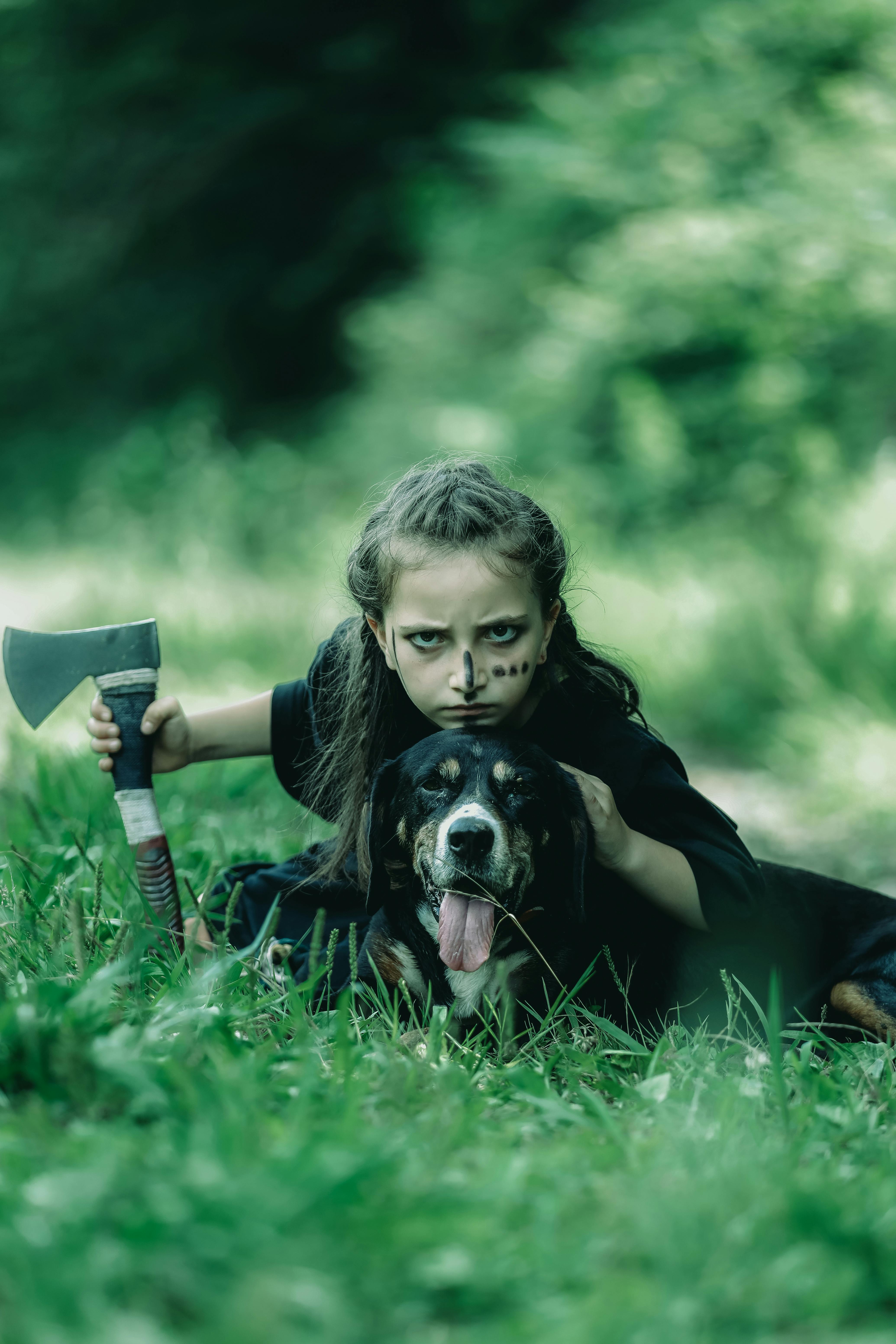 A little girl with an axe and a dog · Free Stock Photo