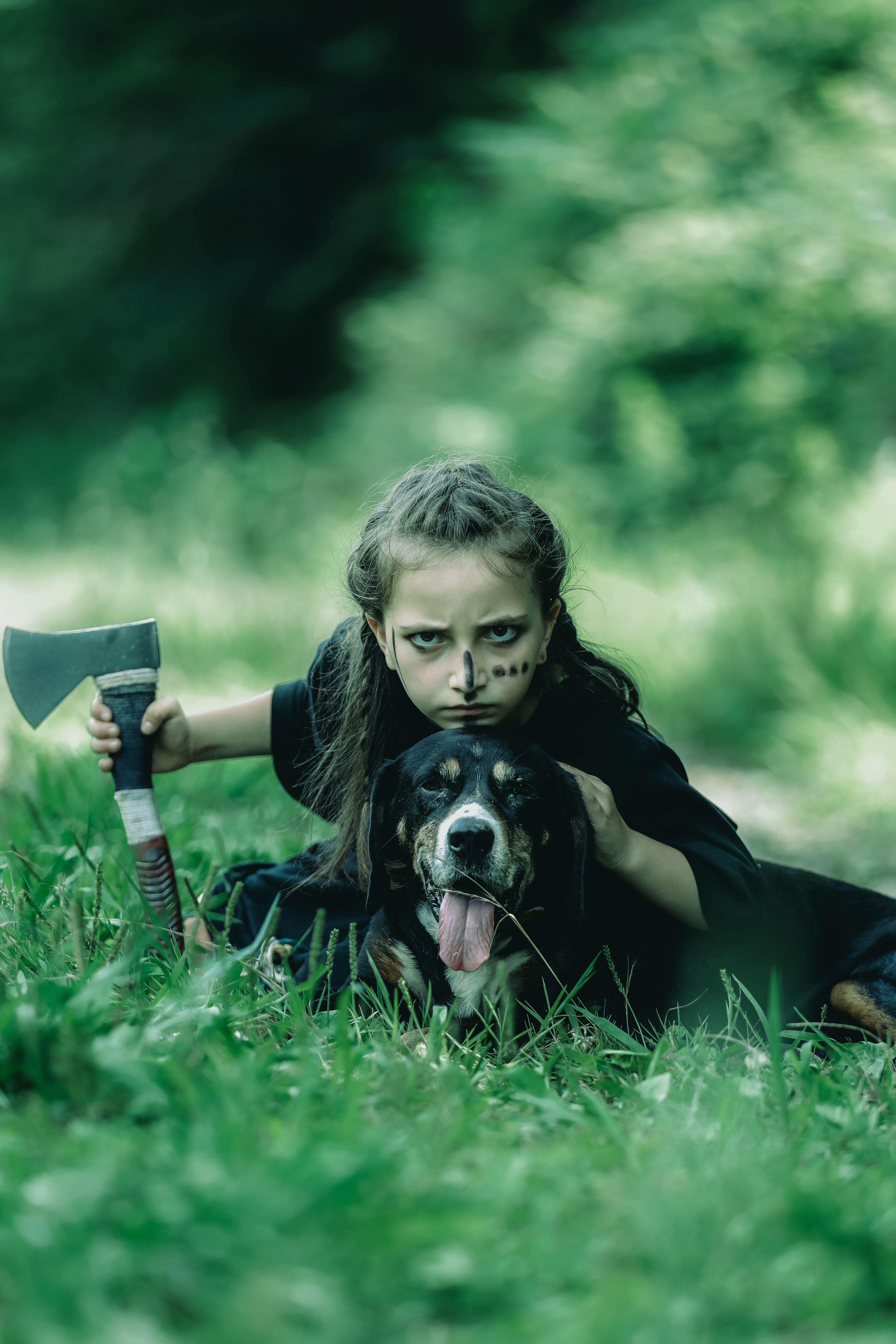 Girl Holding an Axe Lying and Posing with her Dog · Free Stock Photo