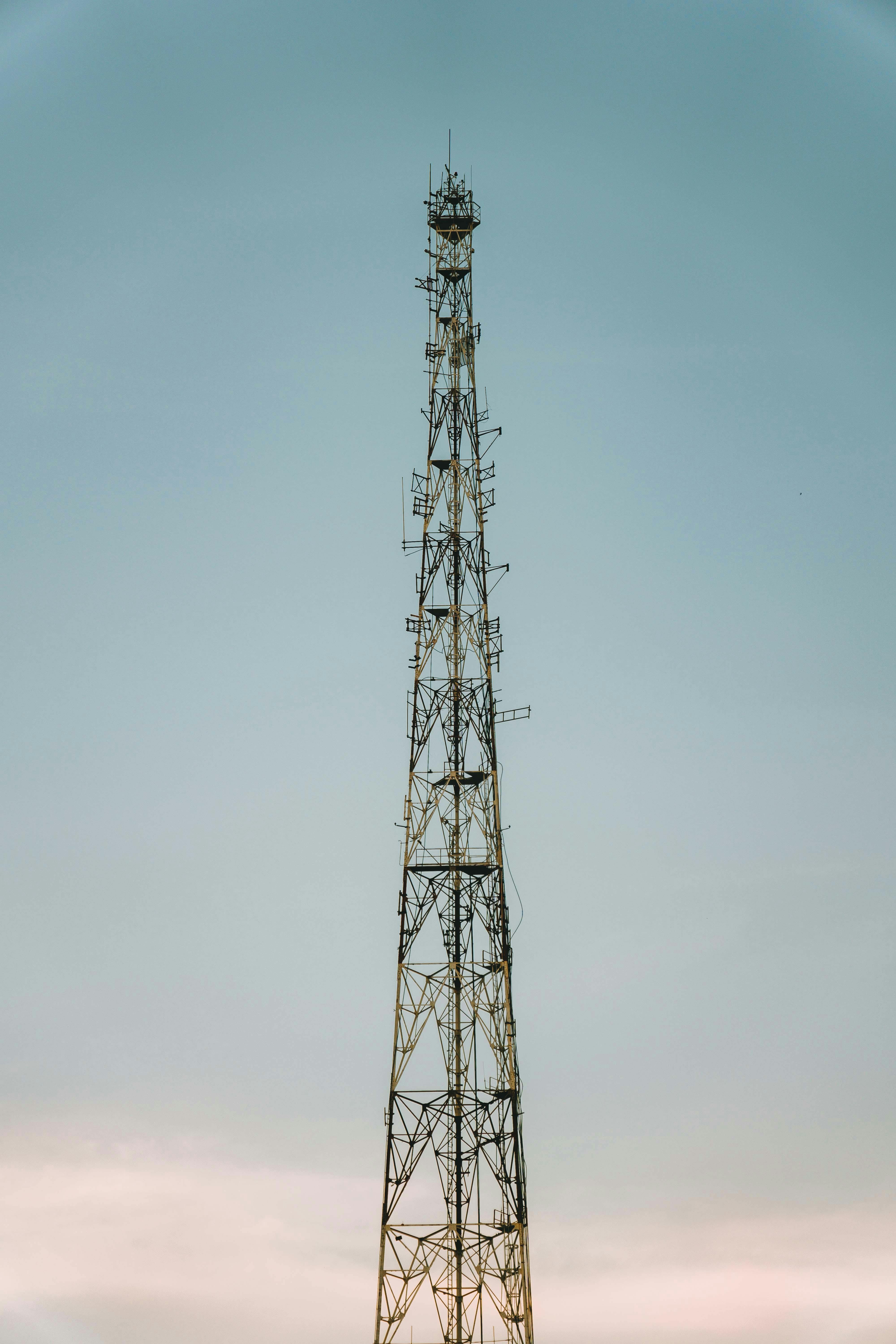 A tall tower with a cell phone tower on top · Free Stock Photo