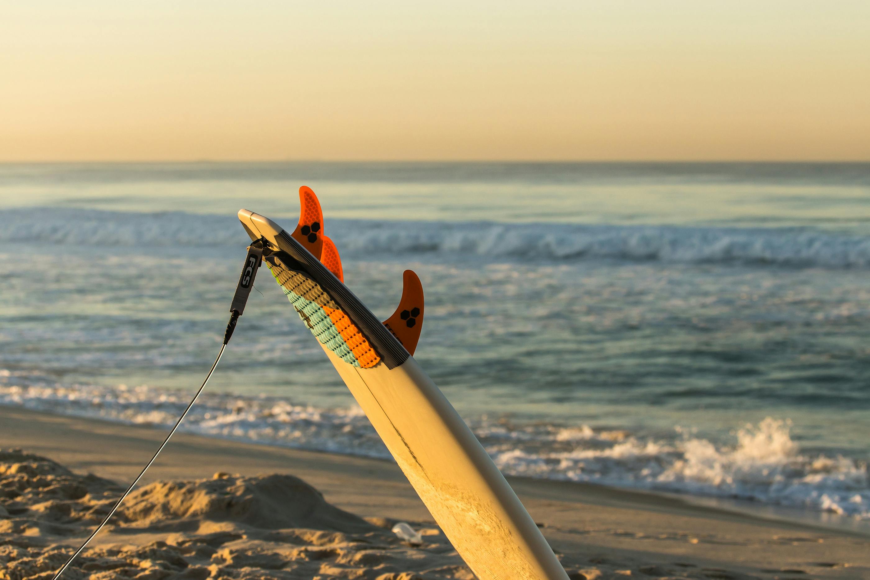 Surfboard on Sandy Beach at Sunrise · Free Stock Photo