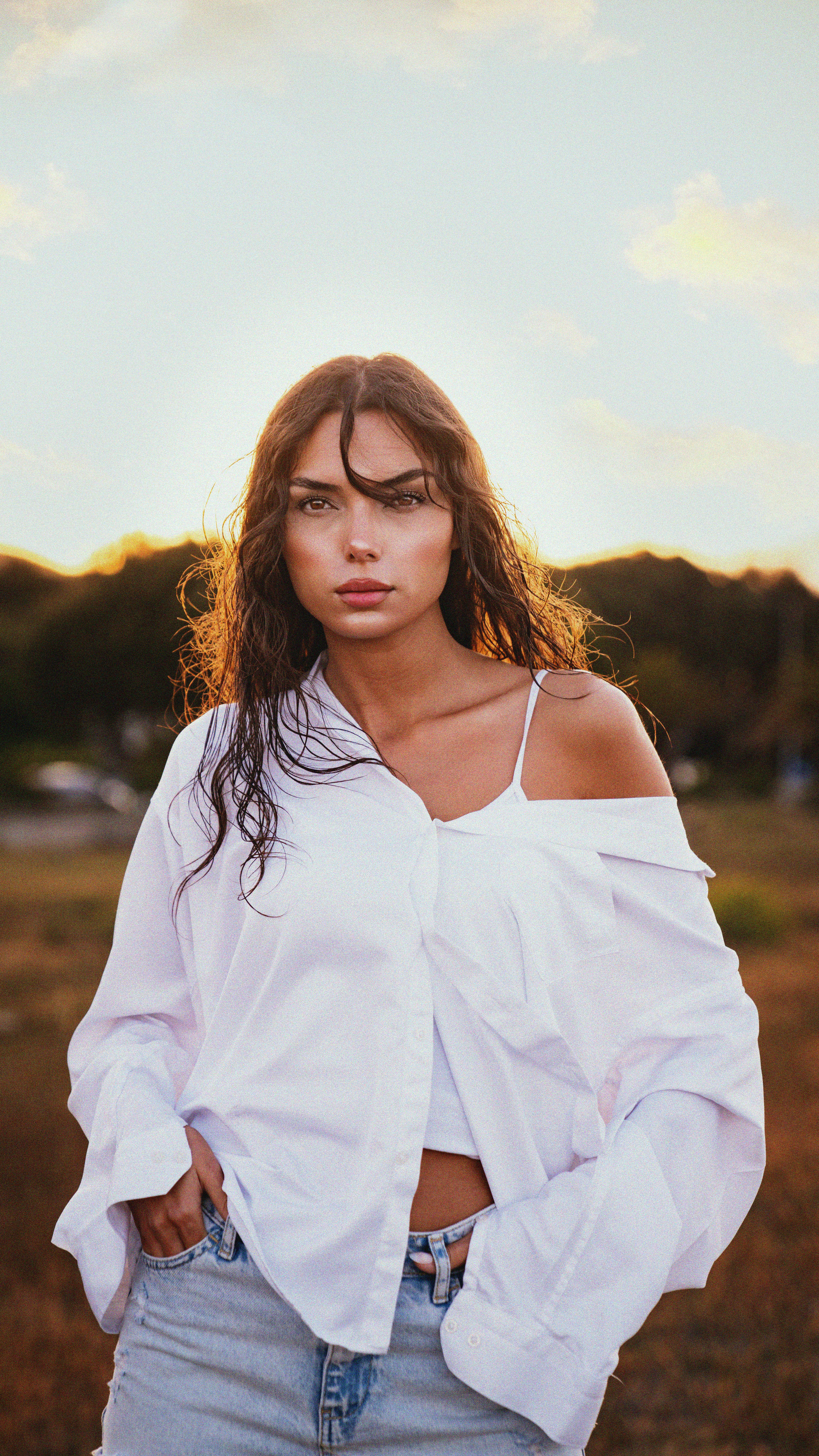 Woman in Unbuttoned Blouse, Tank Top and Jeans Holding Hands in Pockets ...