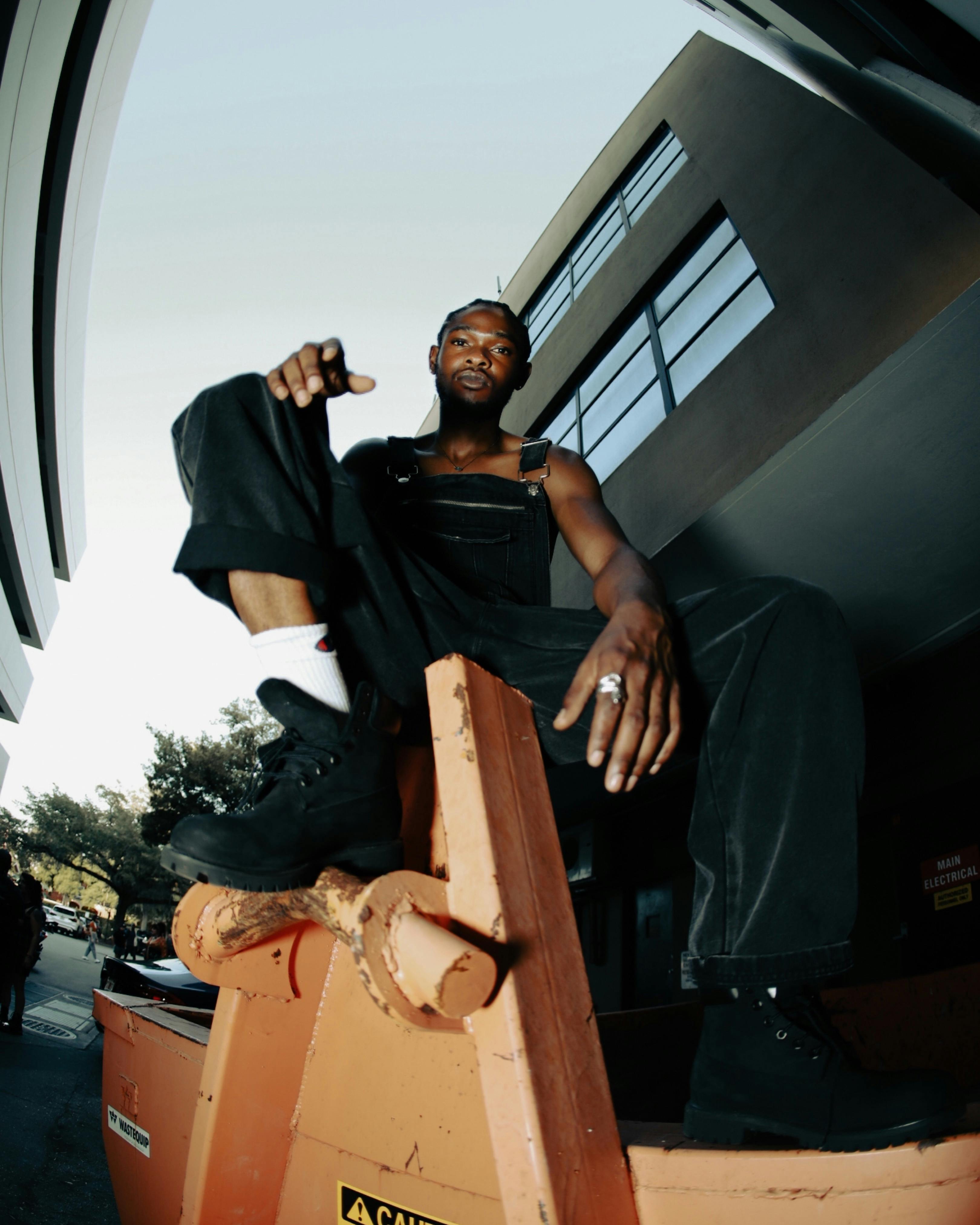 Low Angle Shot of a Man in a Trendy Outfit Posing between the Buildings ...