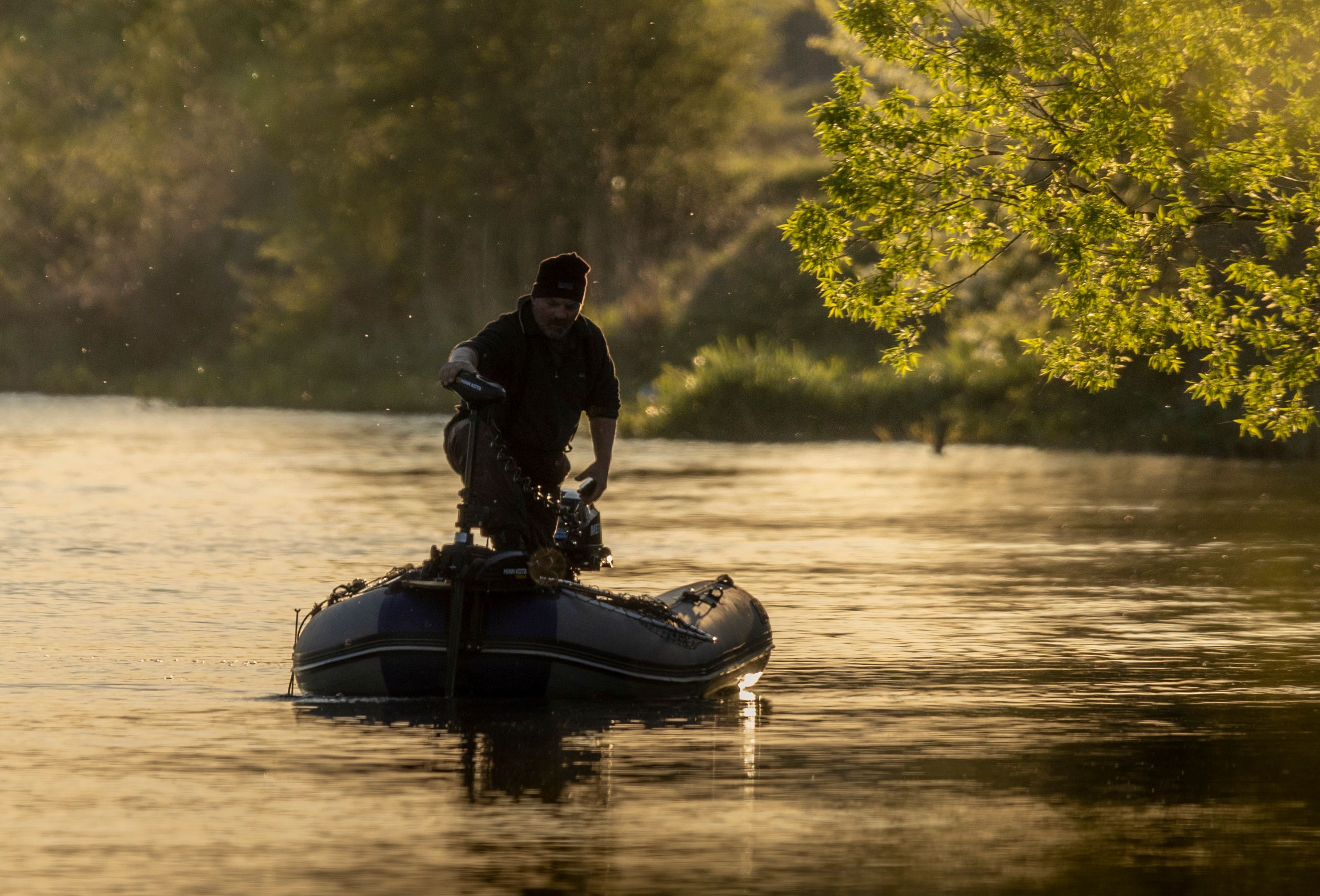 A Man Standing on a Boat on a Body of Water at Sunset · Free Stock Photo