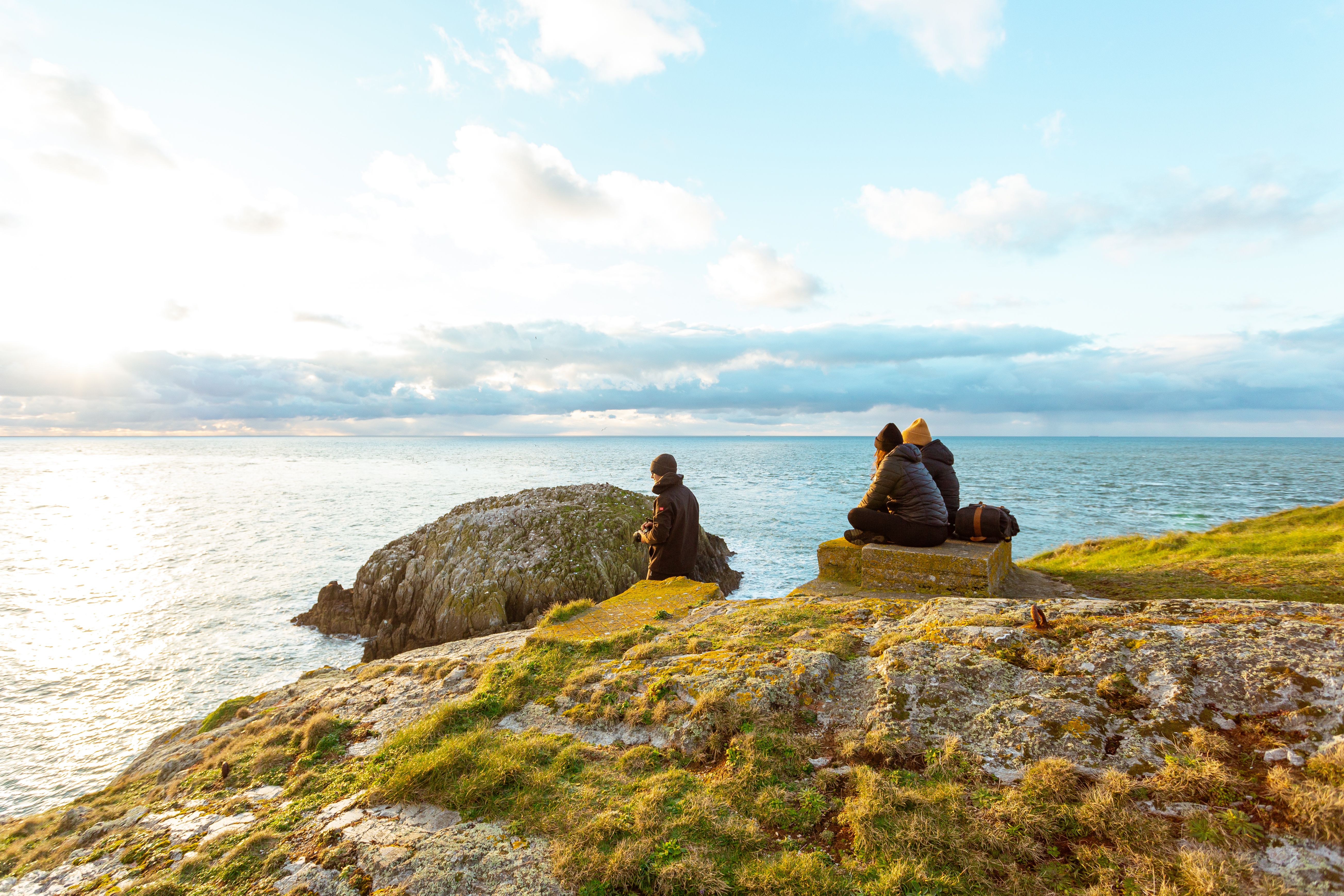 View of People Sitting on the Coast of Anglesey, Wales · Free Stock Photo