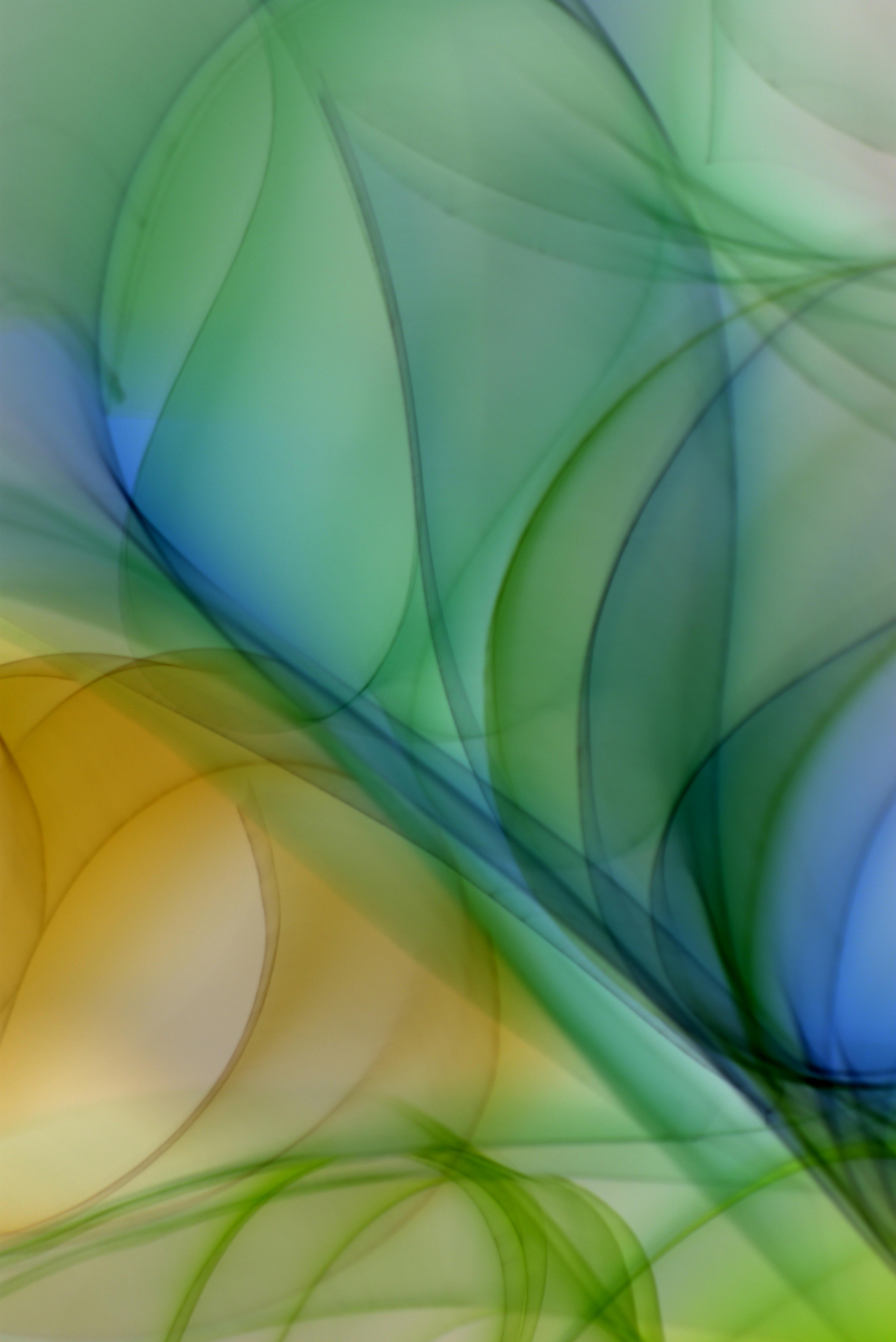 A colorful abstract background with a green, blue and yellow swirl ...