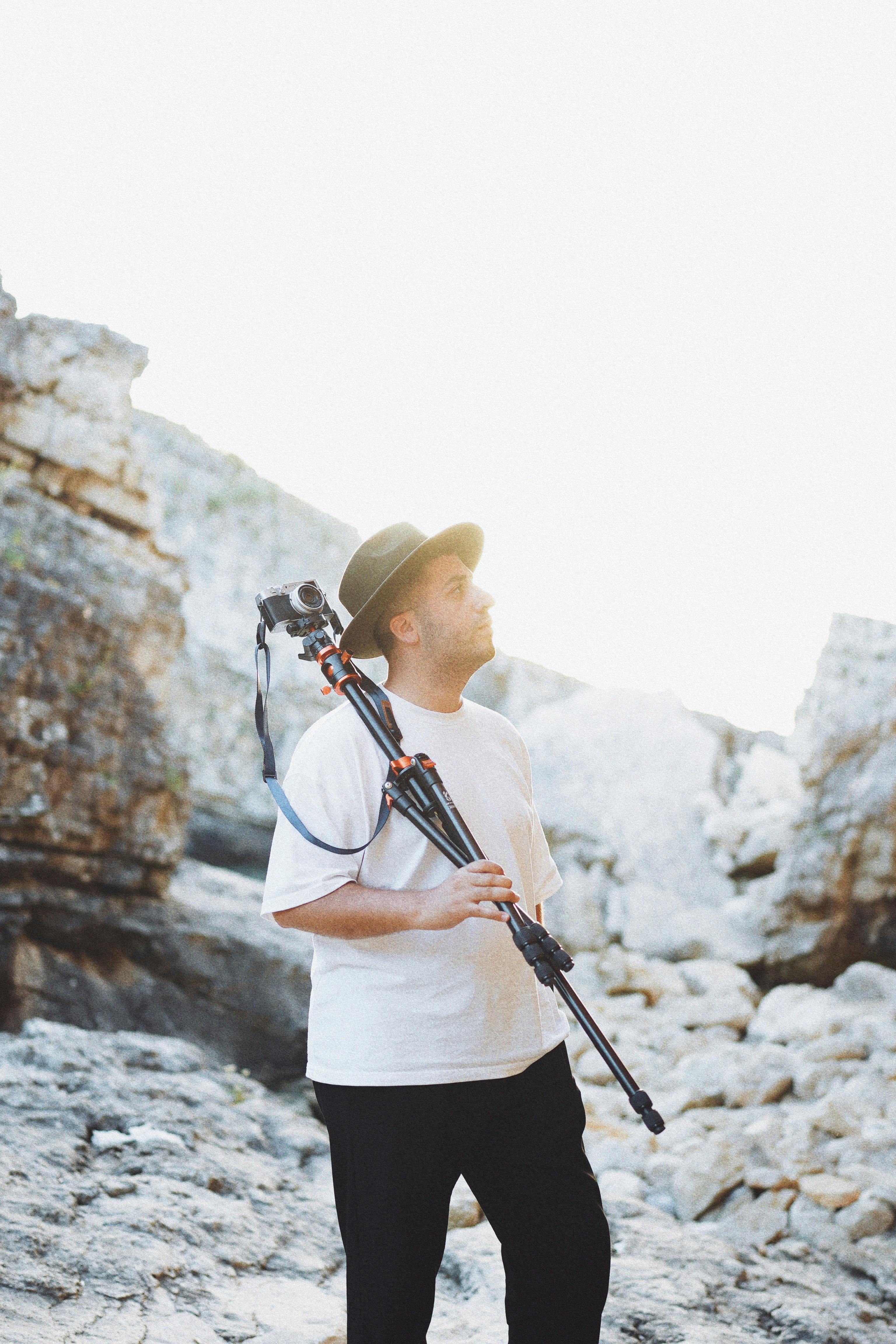Man Holding Tripod with Camera Posing between Rock Formations · Free ...