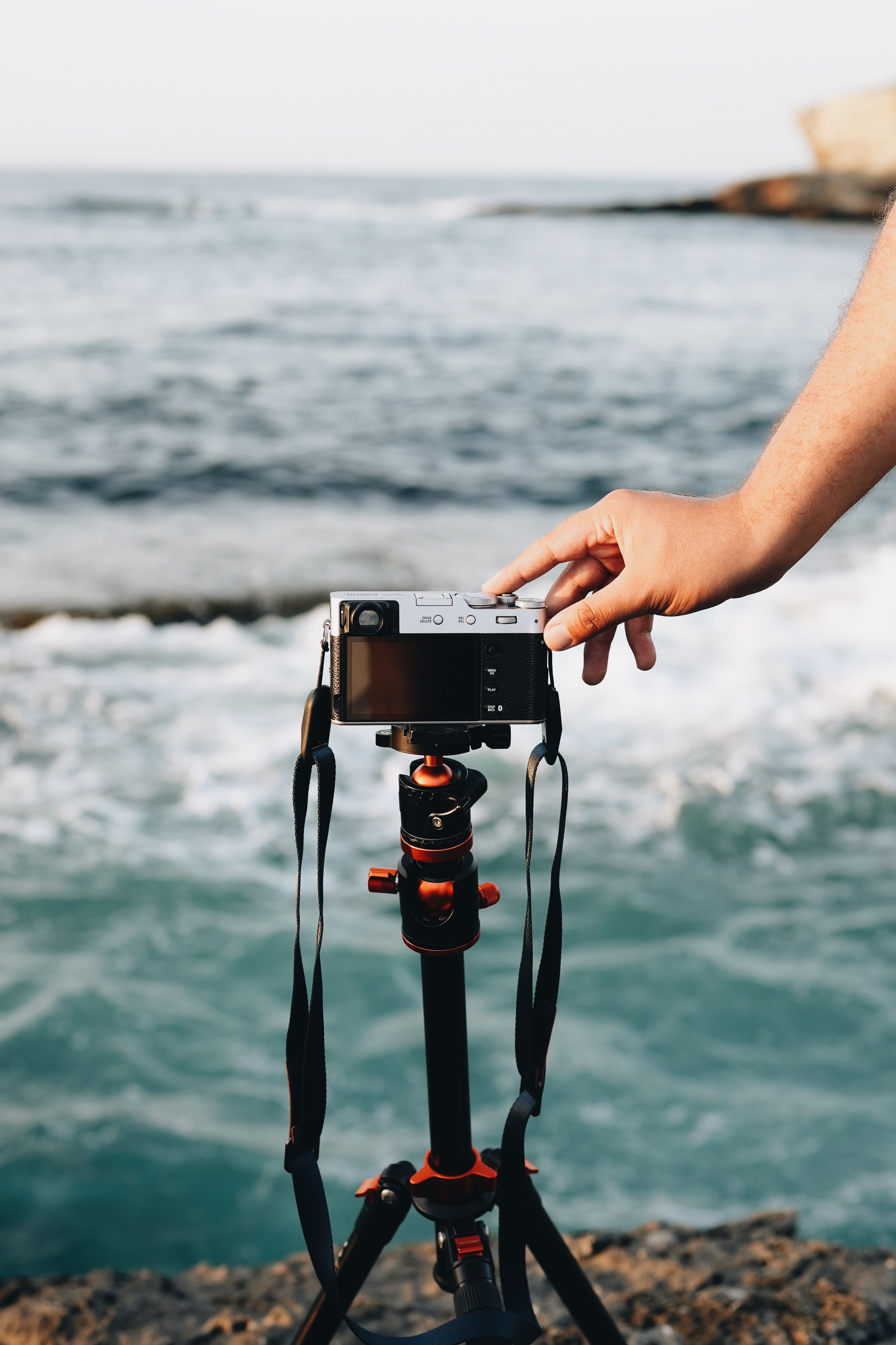 Hand Pushing on Camera Button by the Sea · Free Stock Photo