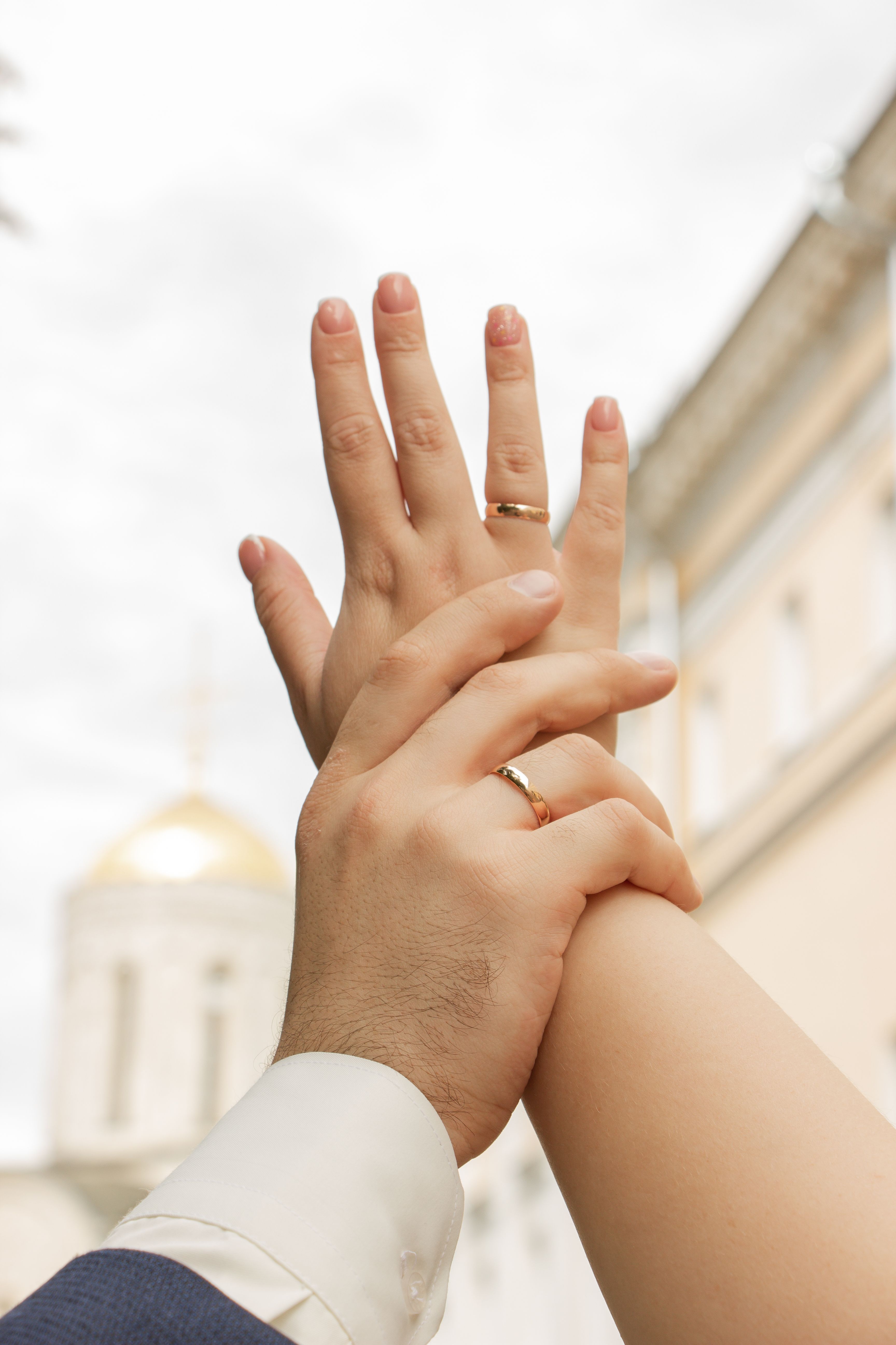 A couple holding hands in front of a church · Free Stock Photo