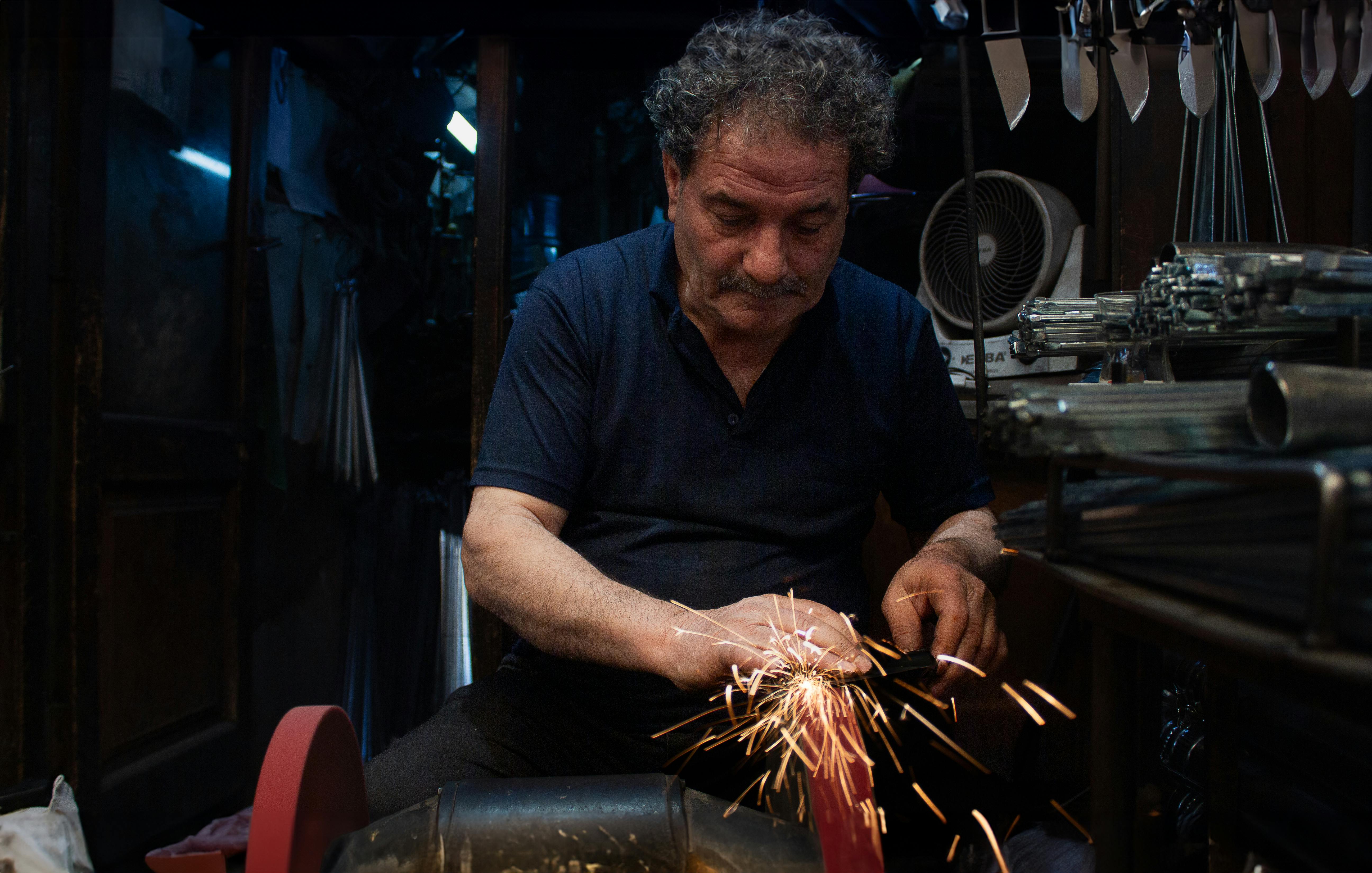 Blacksmith Sitting in Workshop and Working · Free Stock Photo