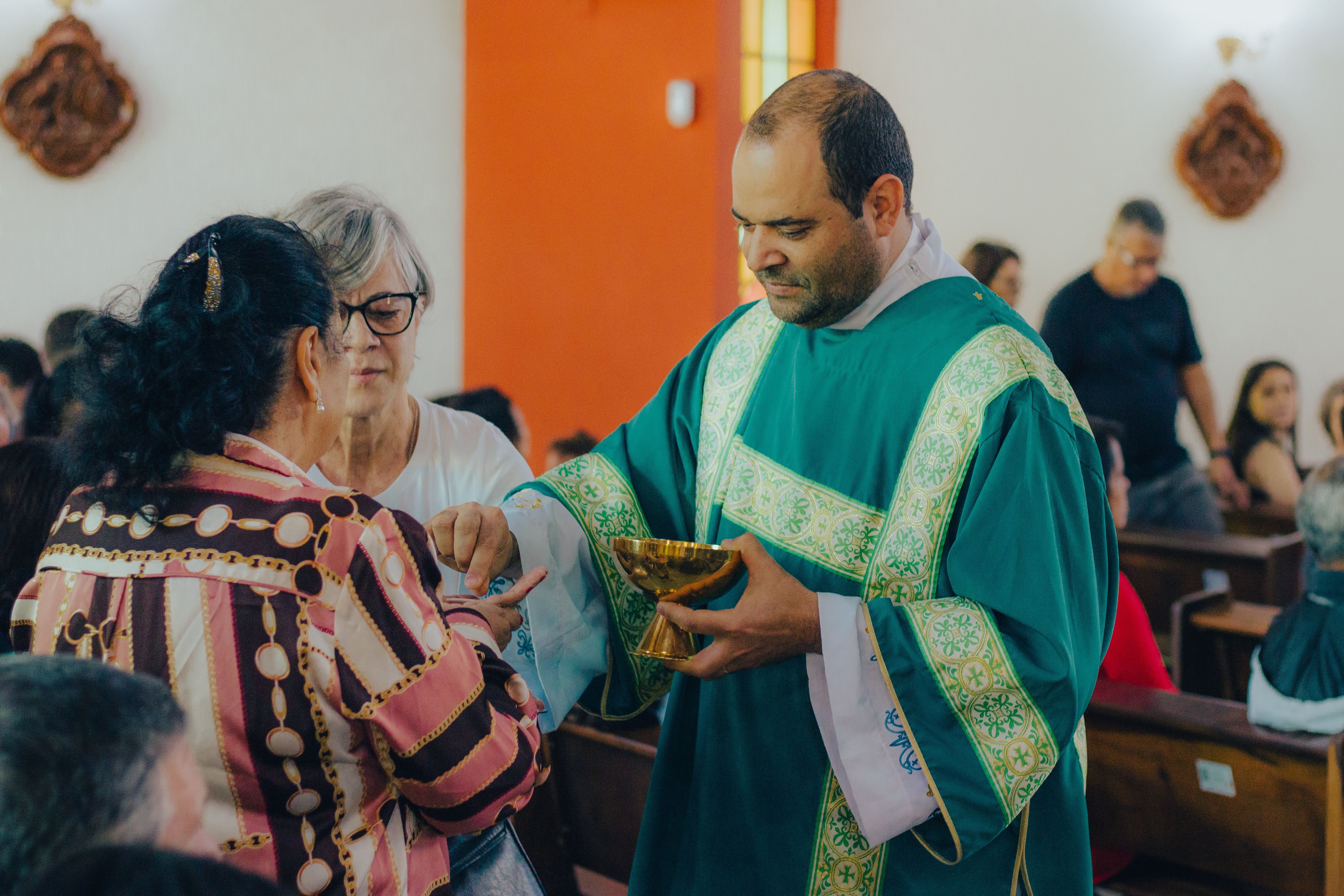 A priest giving a blessing to a woman in a church · Free Stock Photo