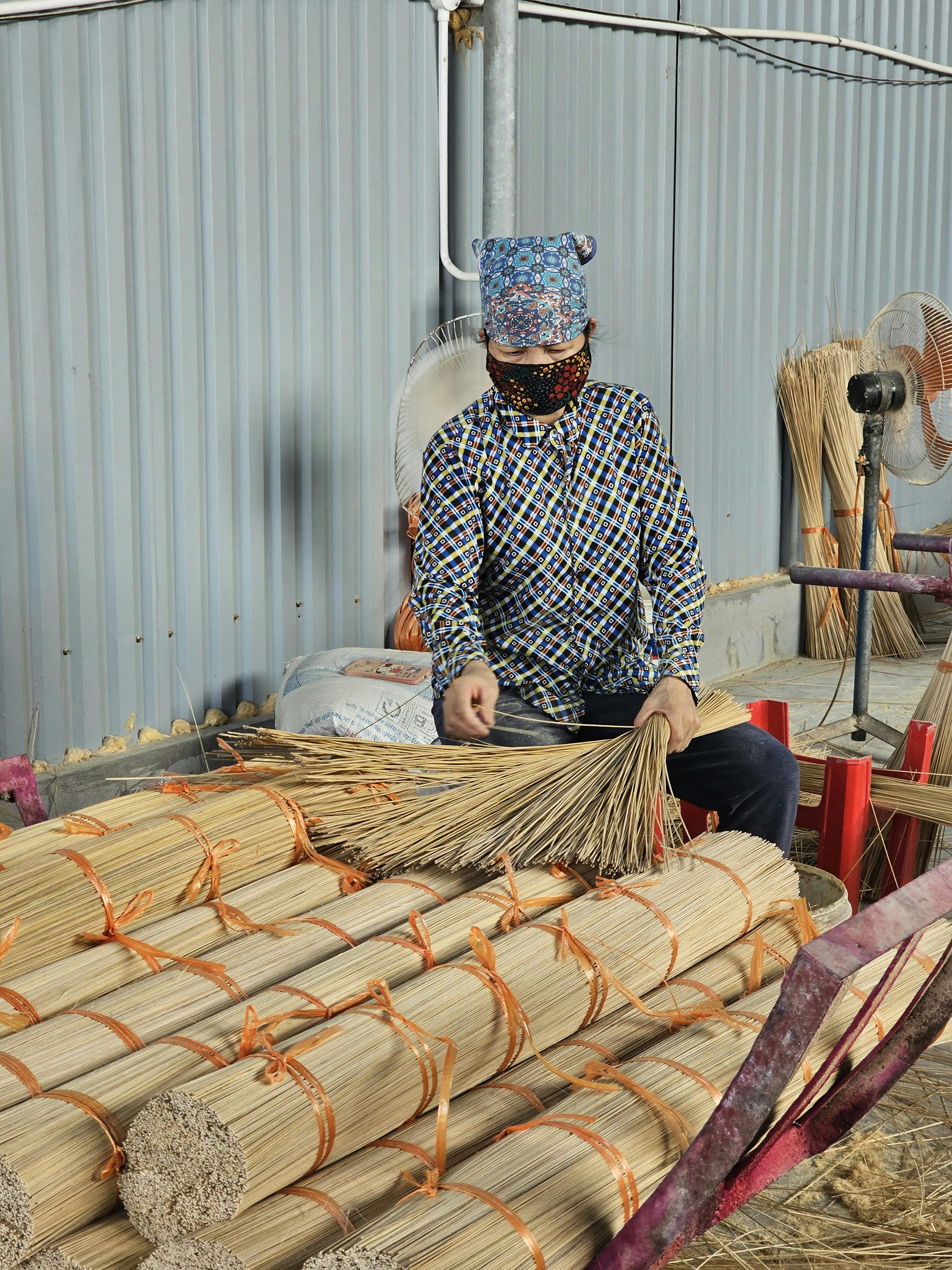 Worker Tying Bundles of Bamboo Sticks · Free Stock Photo
