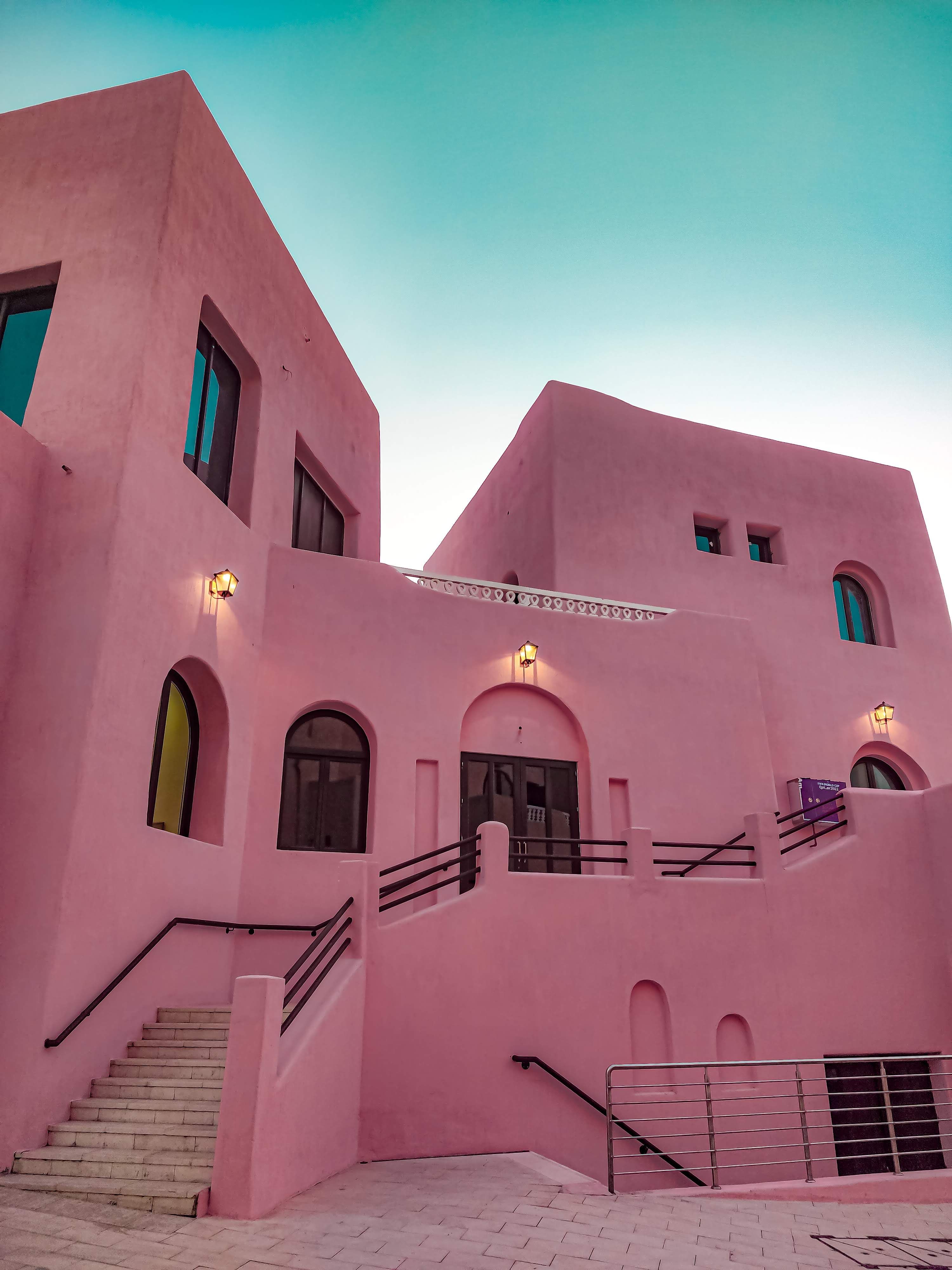 A pink building with stairs and a pink door · Free Stock Photo