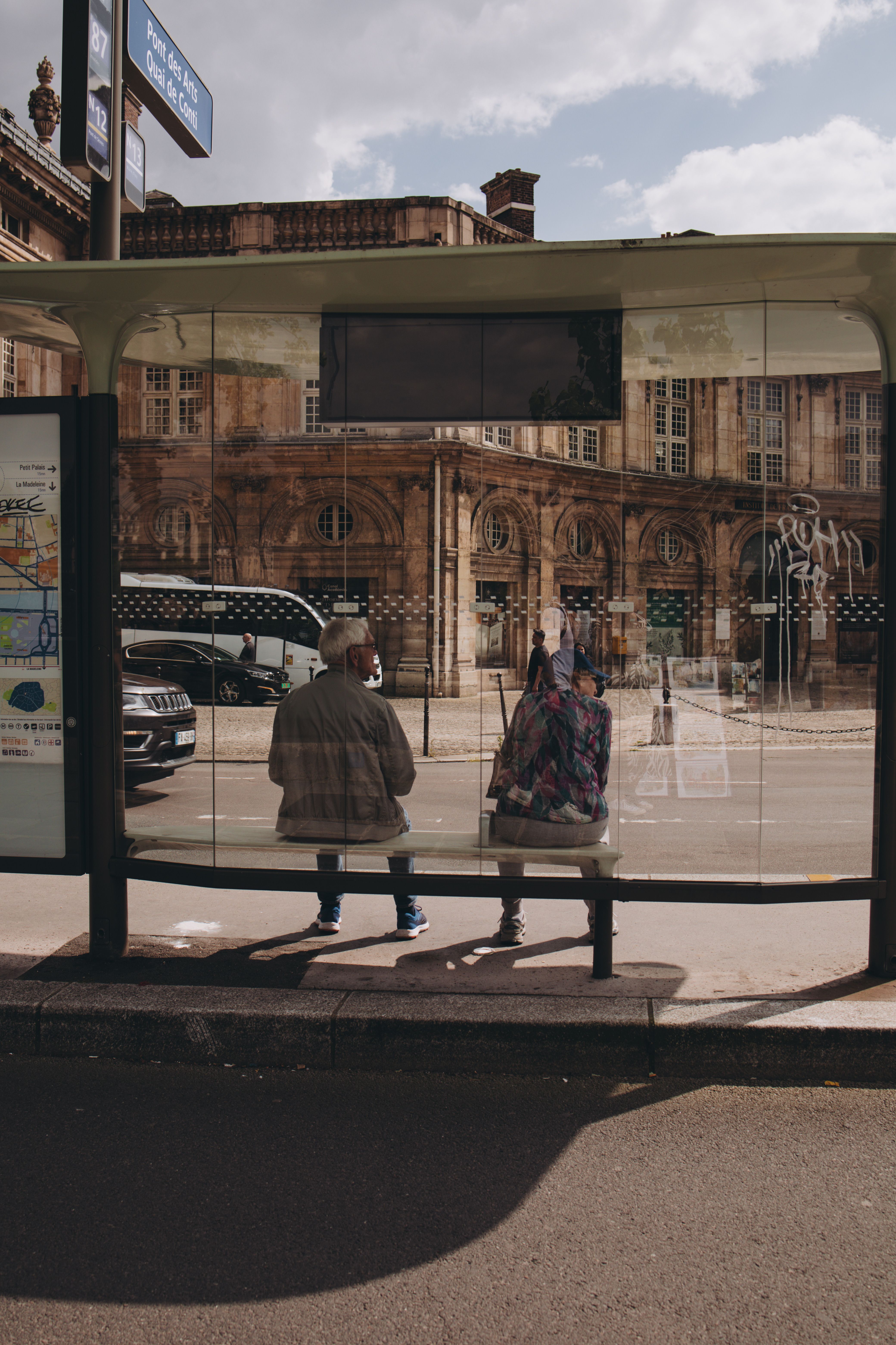 People Sitting on Bus Stop in Sunlight · Free Stock Photo