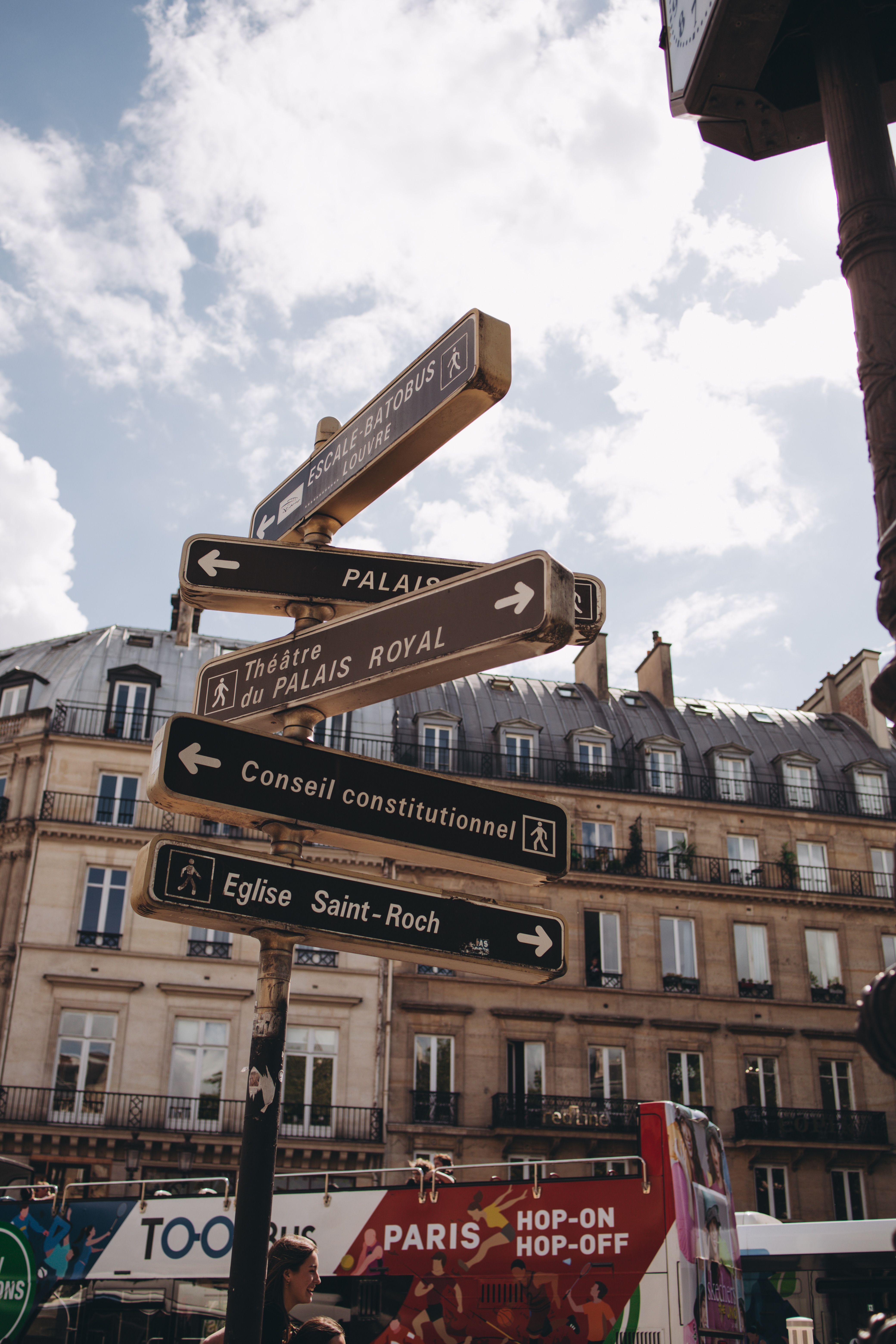 A street sign with many different directions pointing to different ...
