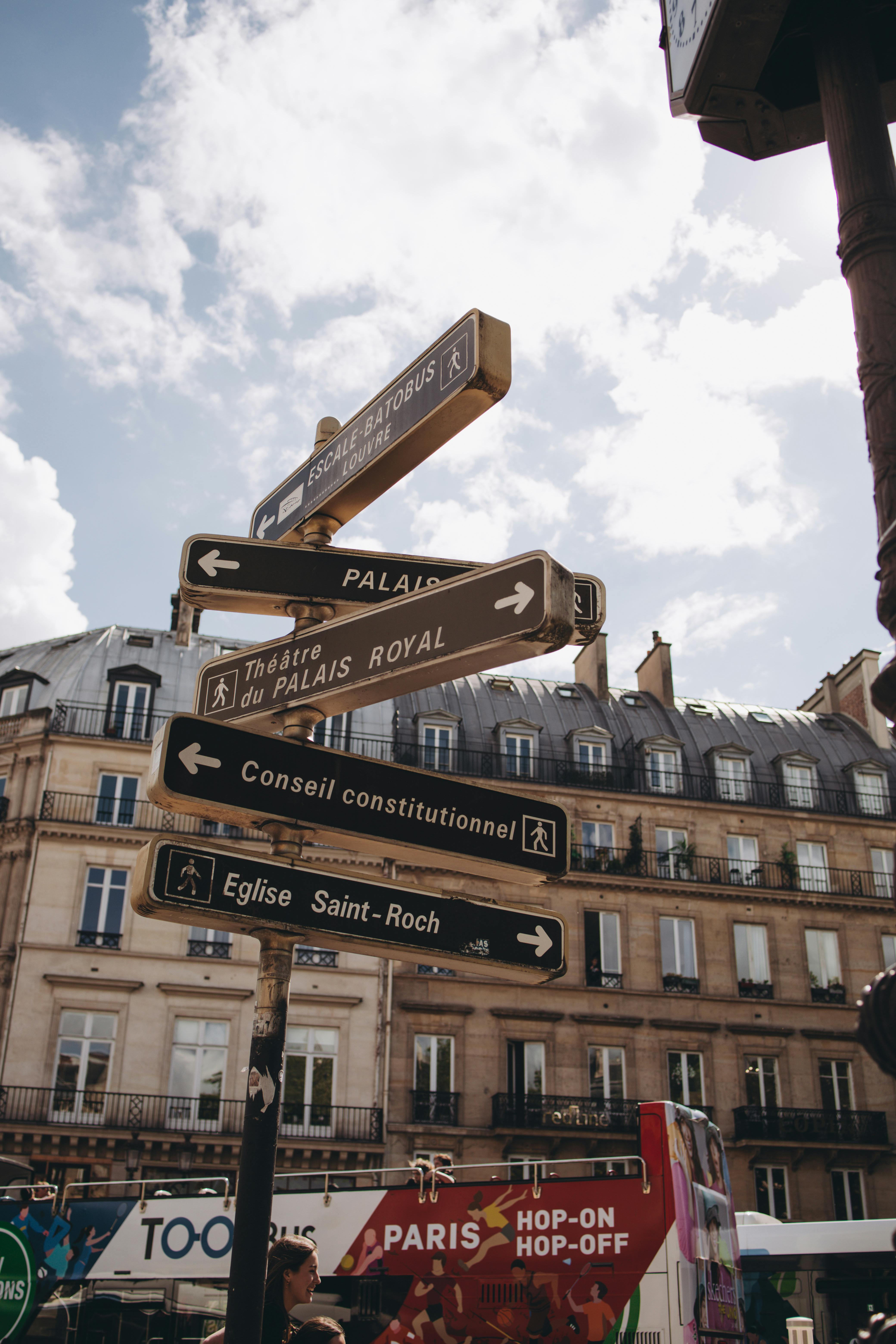 A street sign with many different directions pointing to different ...